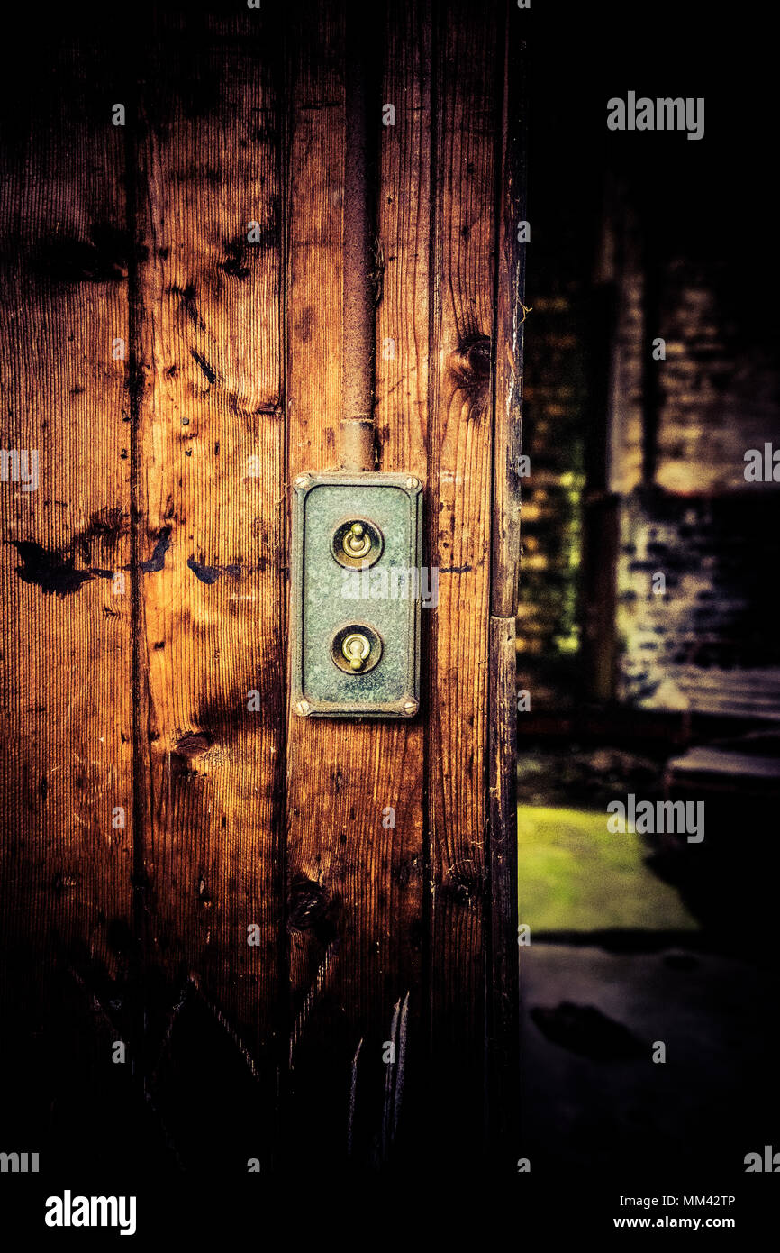 double electrical light switch on wooden wall and room visible behind ...