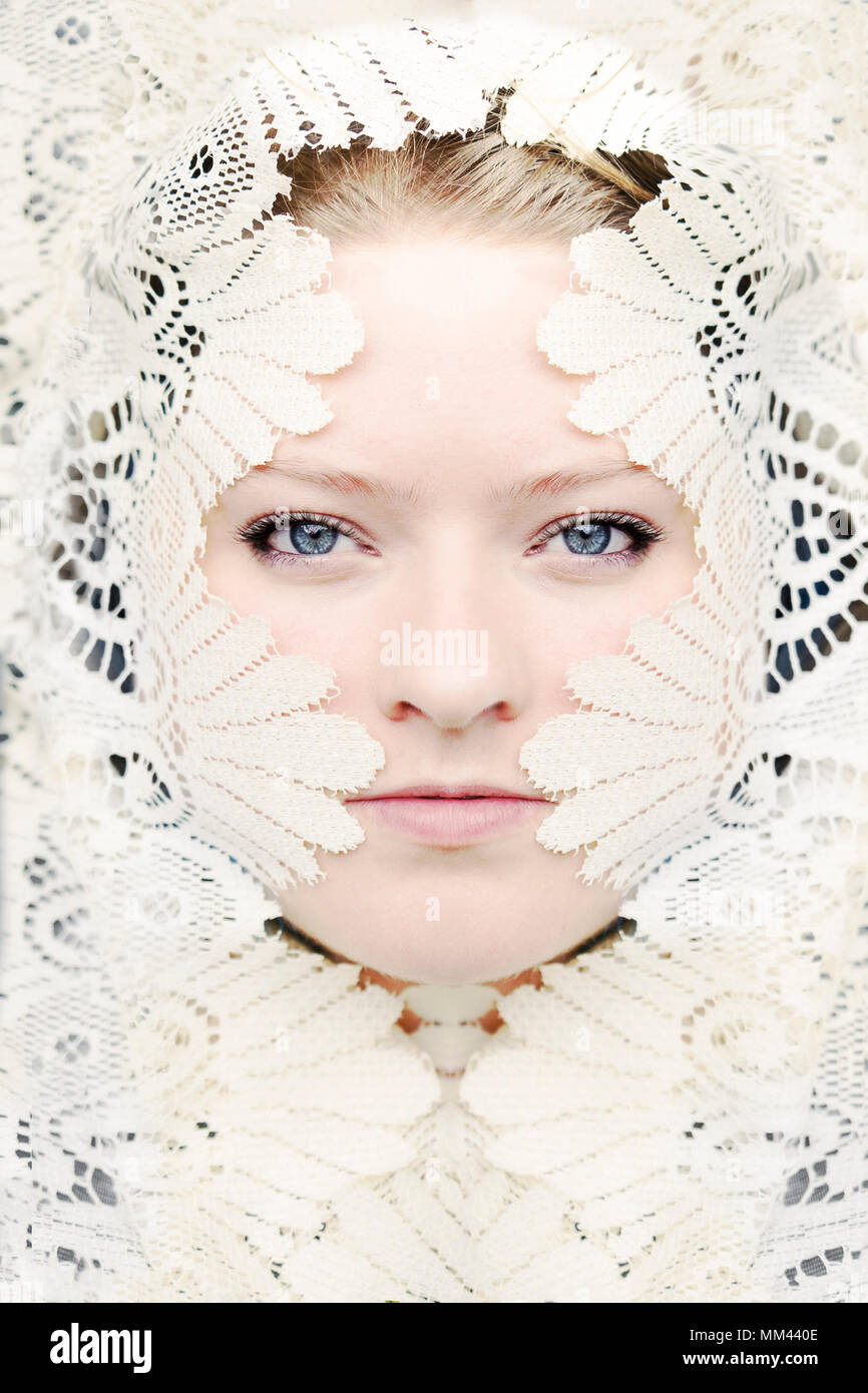 portrait of a young blonde caucasian woman shrouded in white lace, face ...