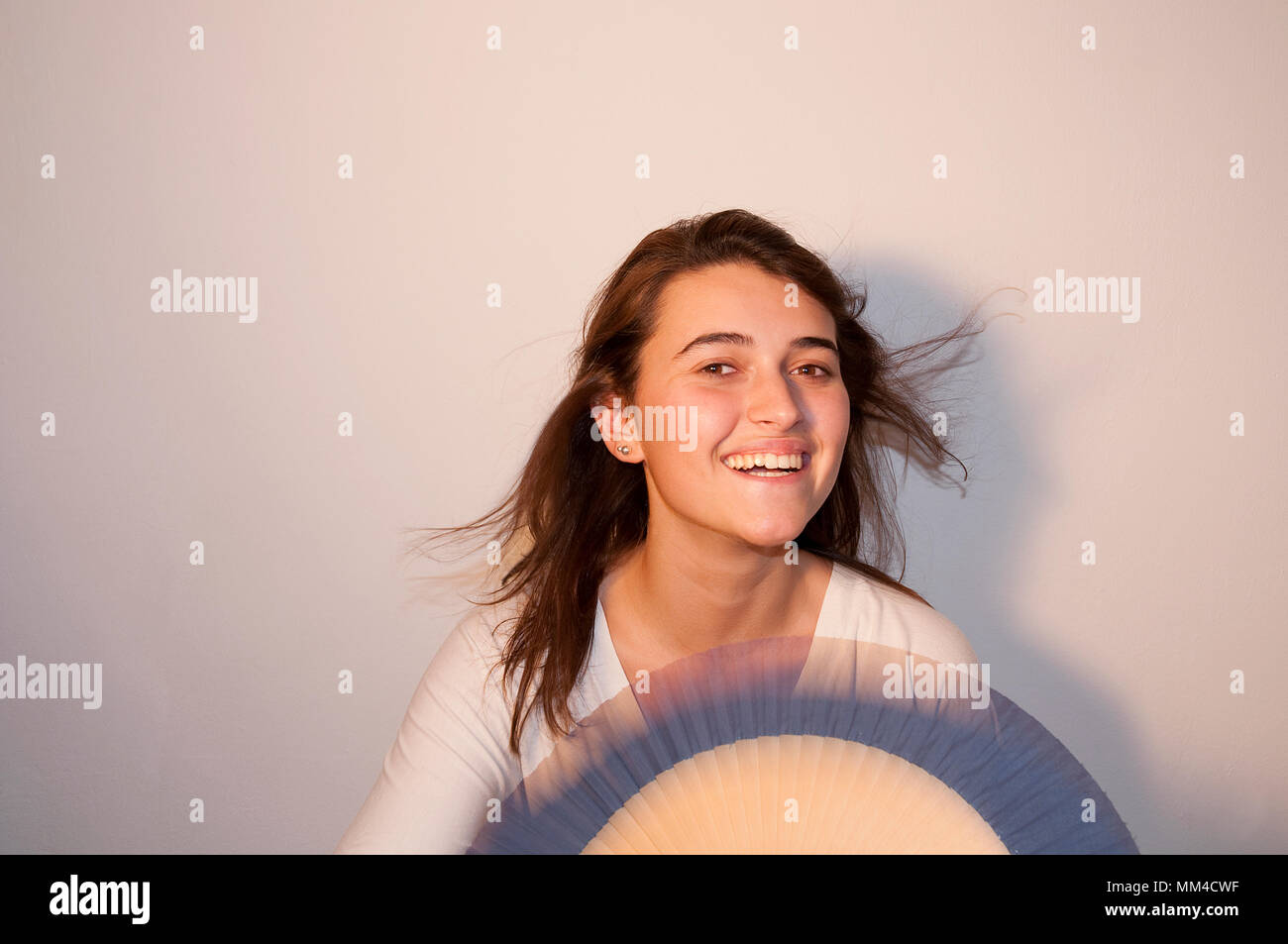 Young woman laughing and fanning herself Stock Photo - Alamy