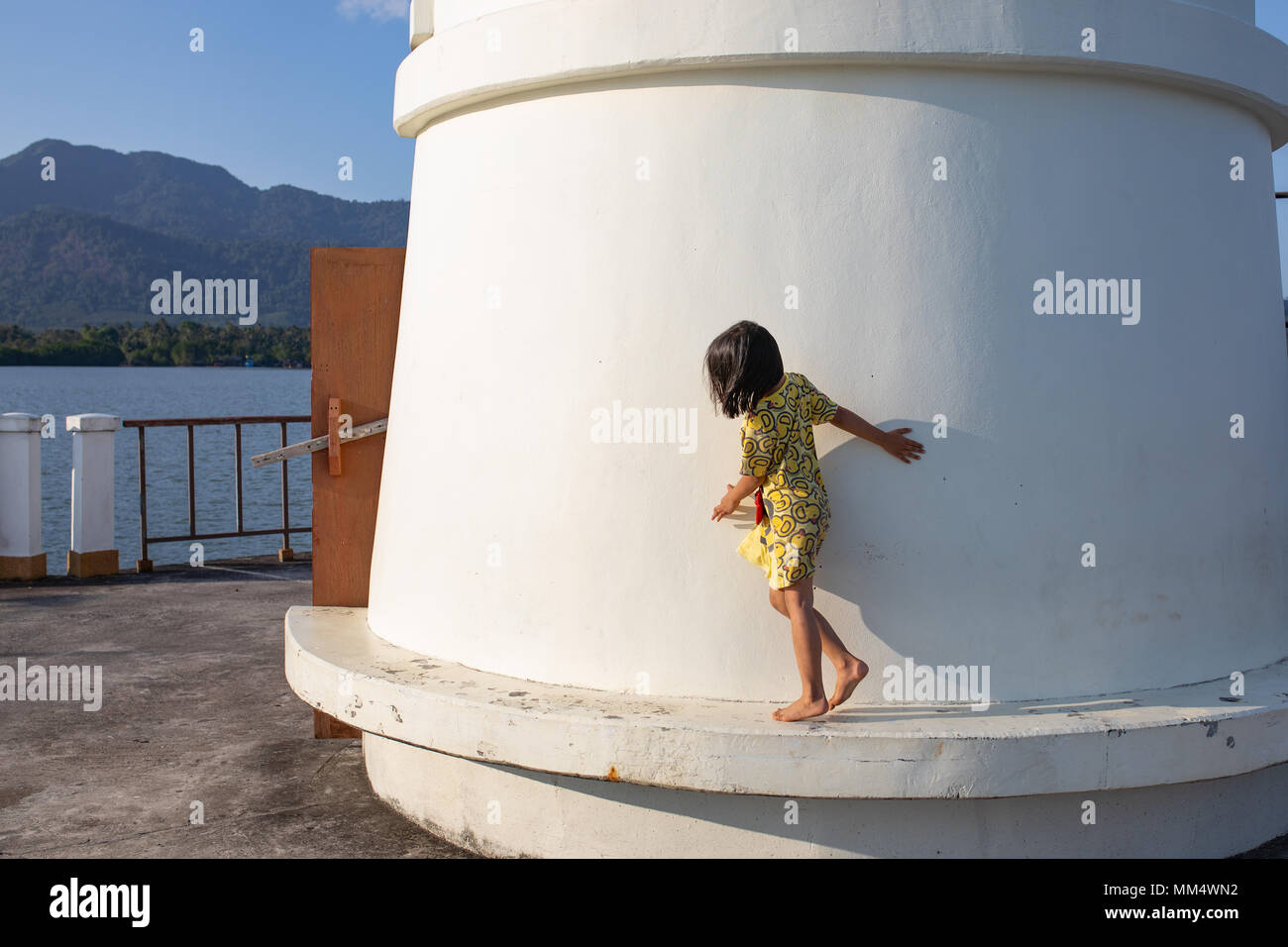 Thailand, Koh Chang. Thai girl catching her shadow, going around a ...