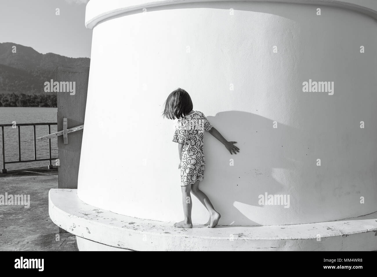 Thailand, Koh Chang. Thai girl catching her shadow, going around a ...