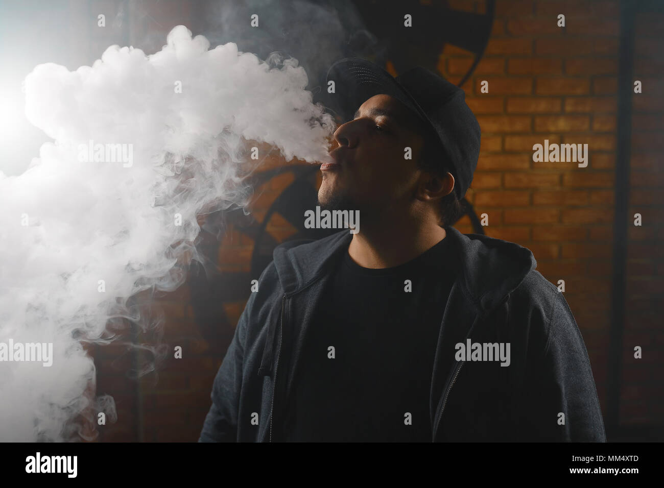 A Cloud Of Vapor Vaping Man Holding A Mod Brick Background Vape Concept Young Man With Beard