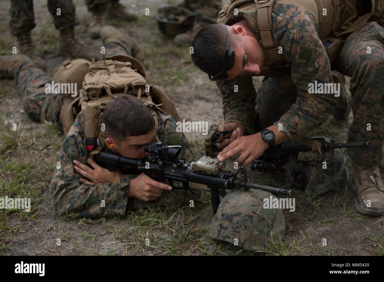 A Marine helps a shooter adjust his rifle’s infrared laser while ...