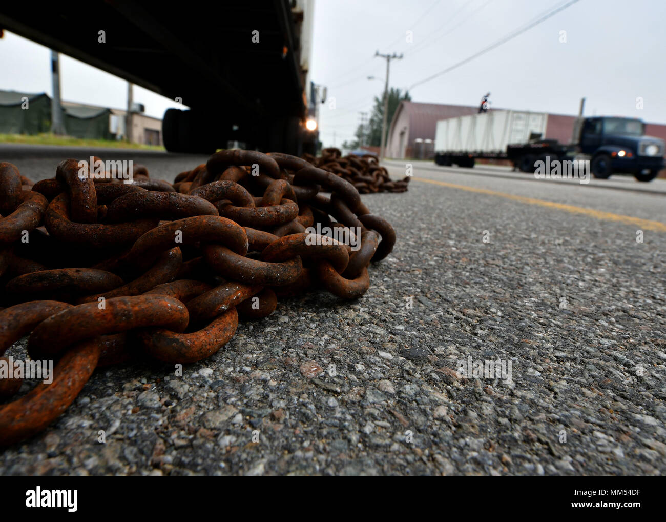 Chains sit on the ground beside trucks assigned to the 51st Logistics ...