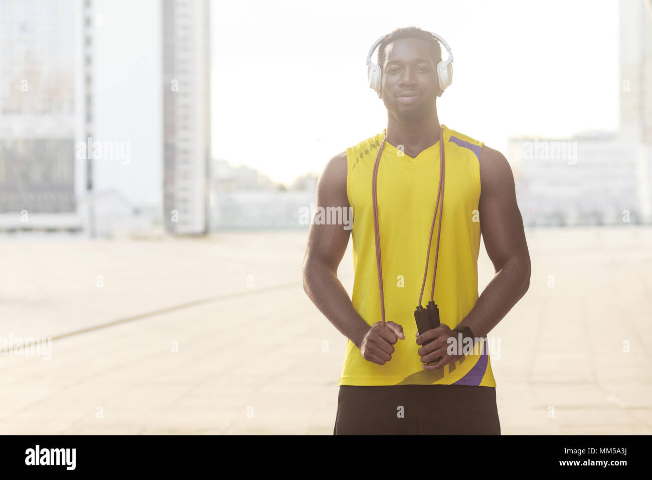 Closeup portrait of handsome sporty afro man holding jump rope. Outdoor ...
