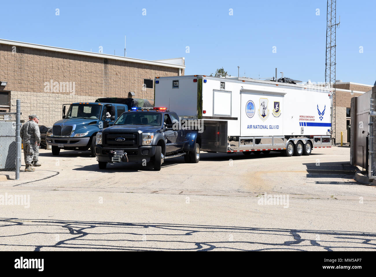 A Mobile Emergency Operations Center (MEOC) and support truck with a ...