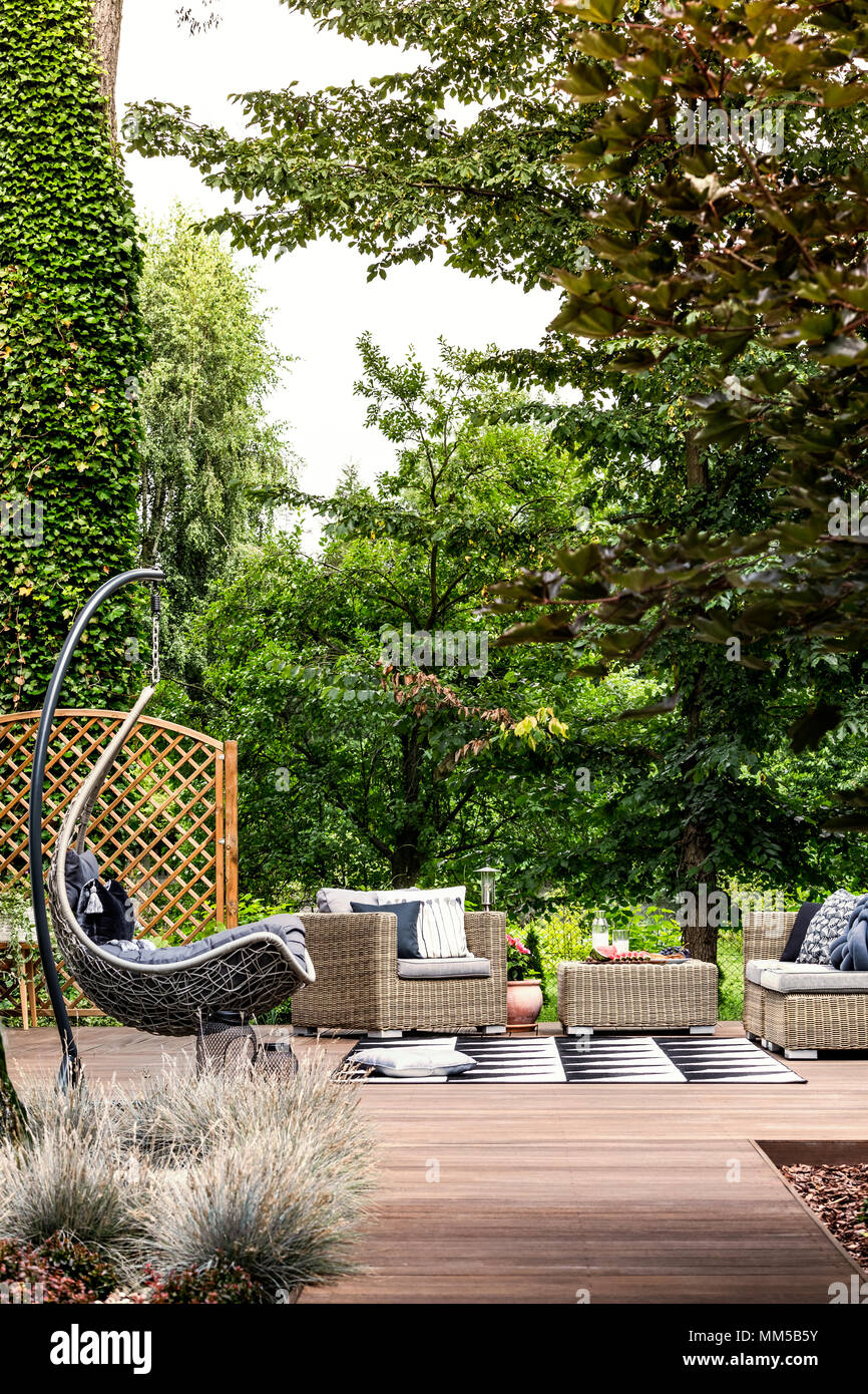 Outdoor area of a summer retreat with cozy garden furniture on a sunny ...