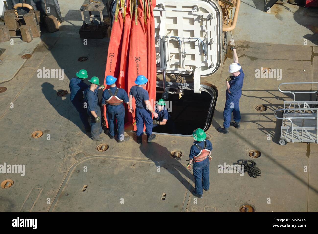 Coast Guard cutter Oak crew members lower gear into the cargo hold on ...