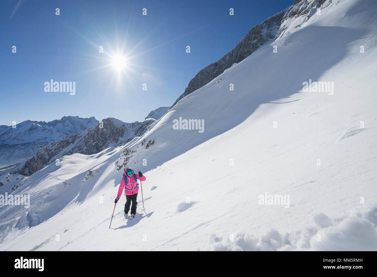 High angle of a woman climbing up the ski slope, Bavaria, Germany ...
