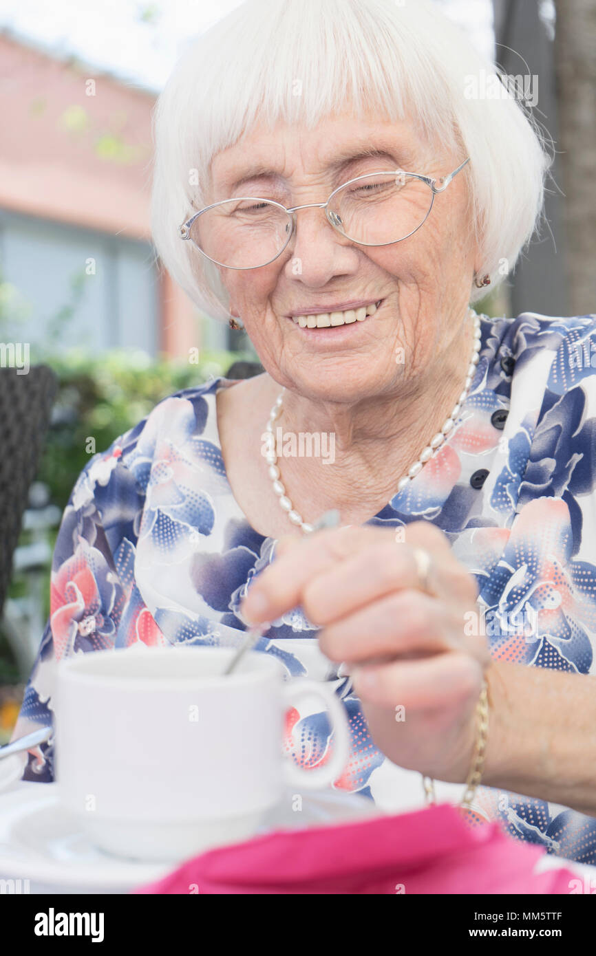 Senior woman stirring tea Stock Photo - Alamy