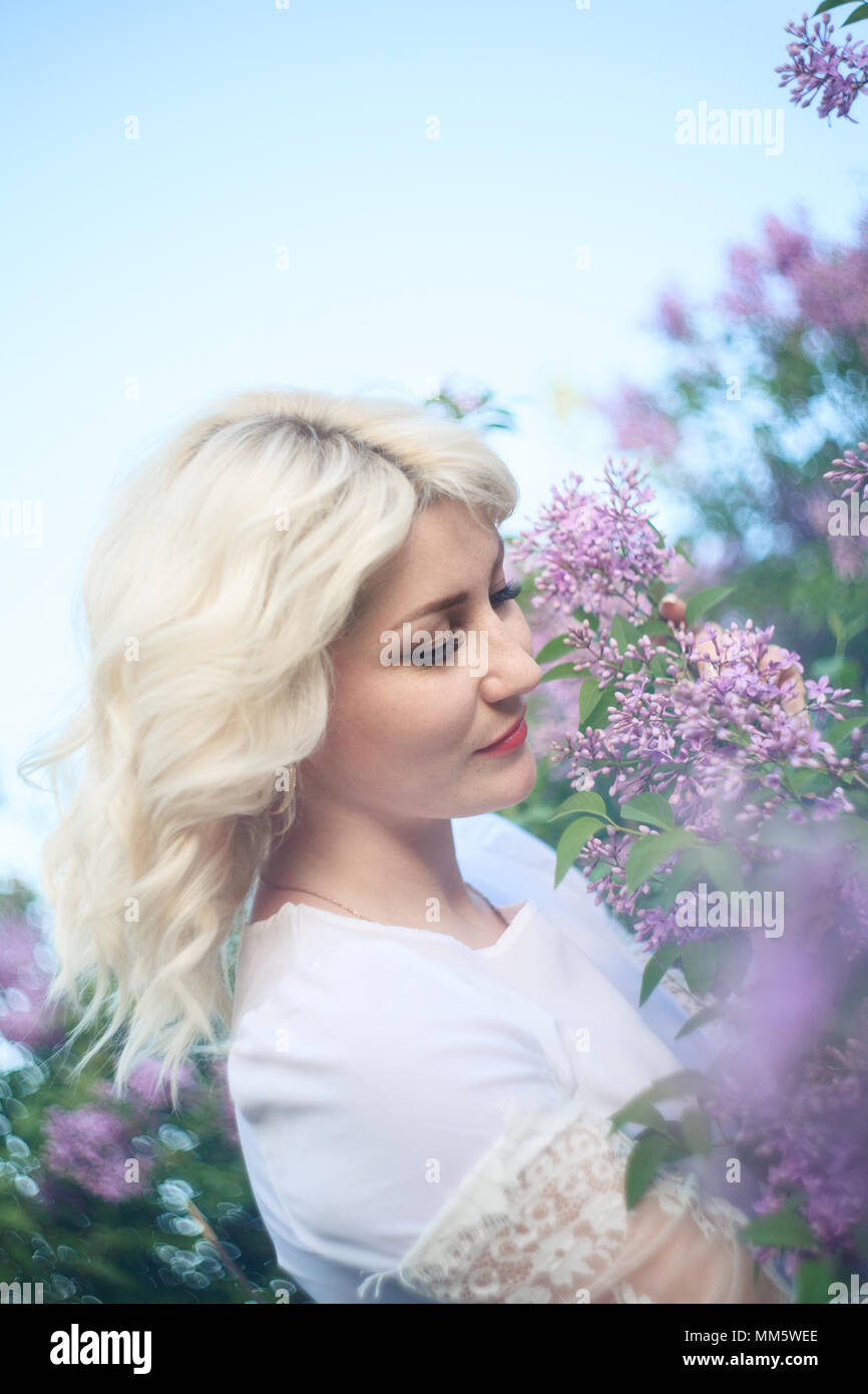 Beautiful woman in a spring garden with blooming lilacs. Concept of ...