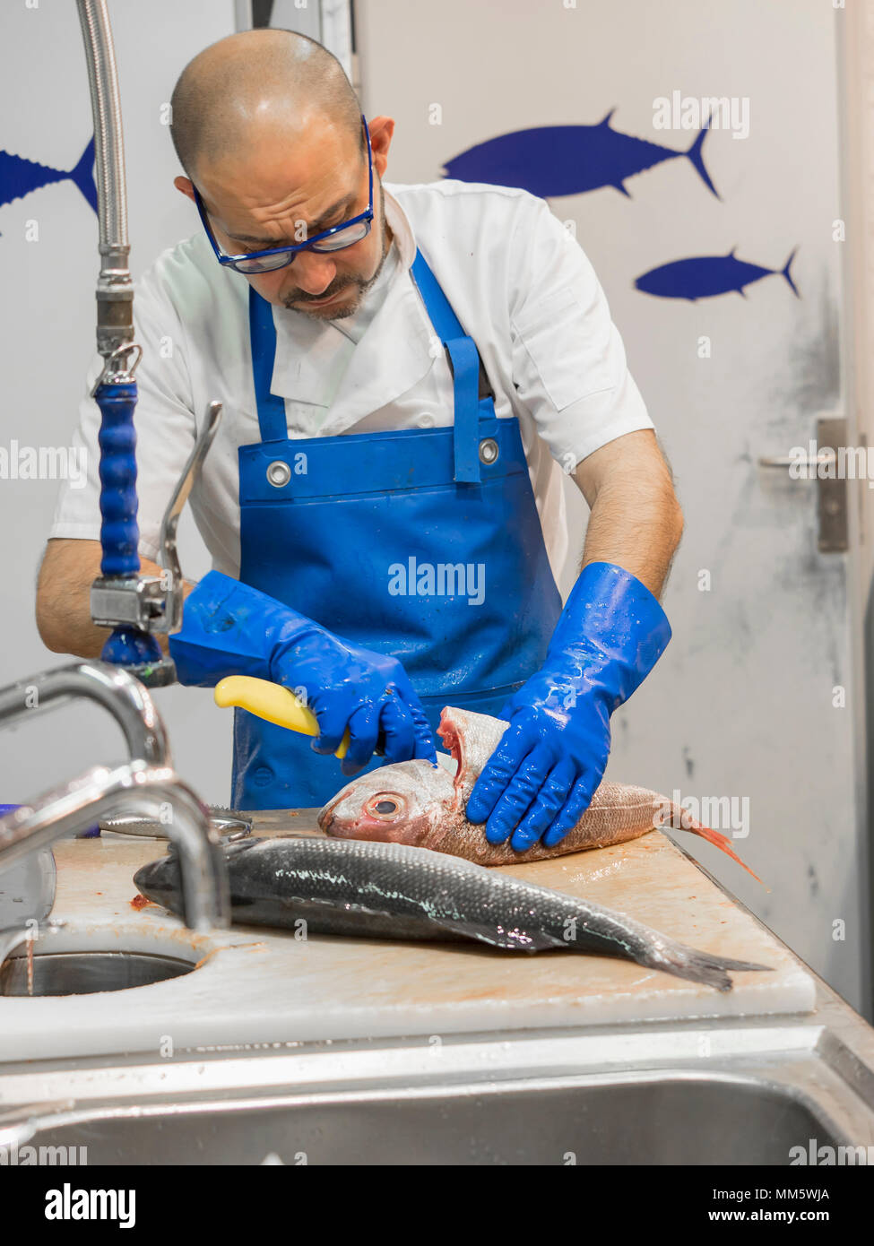 Man preparing fish with knife Stock Photo - Alamy