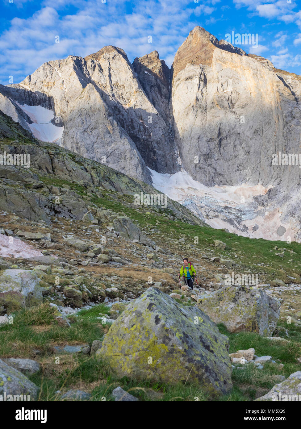 Woman hiking in the High Pyrenees ascending to mount Vignemale ...