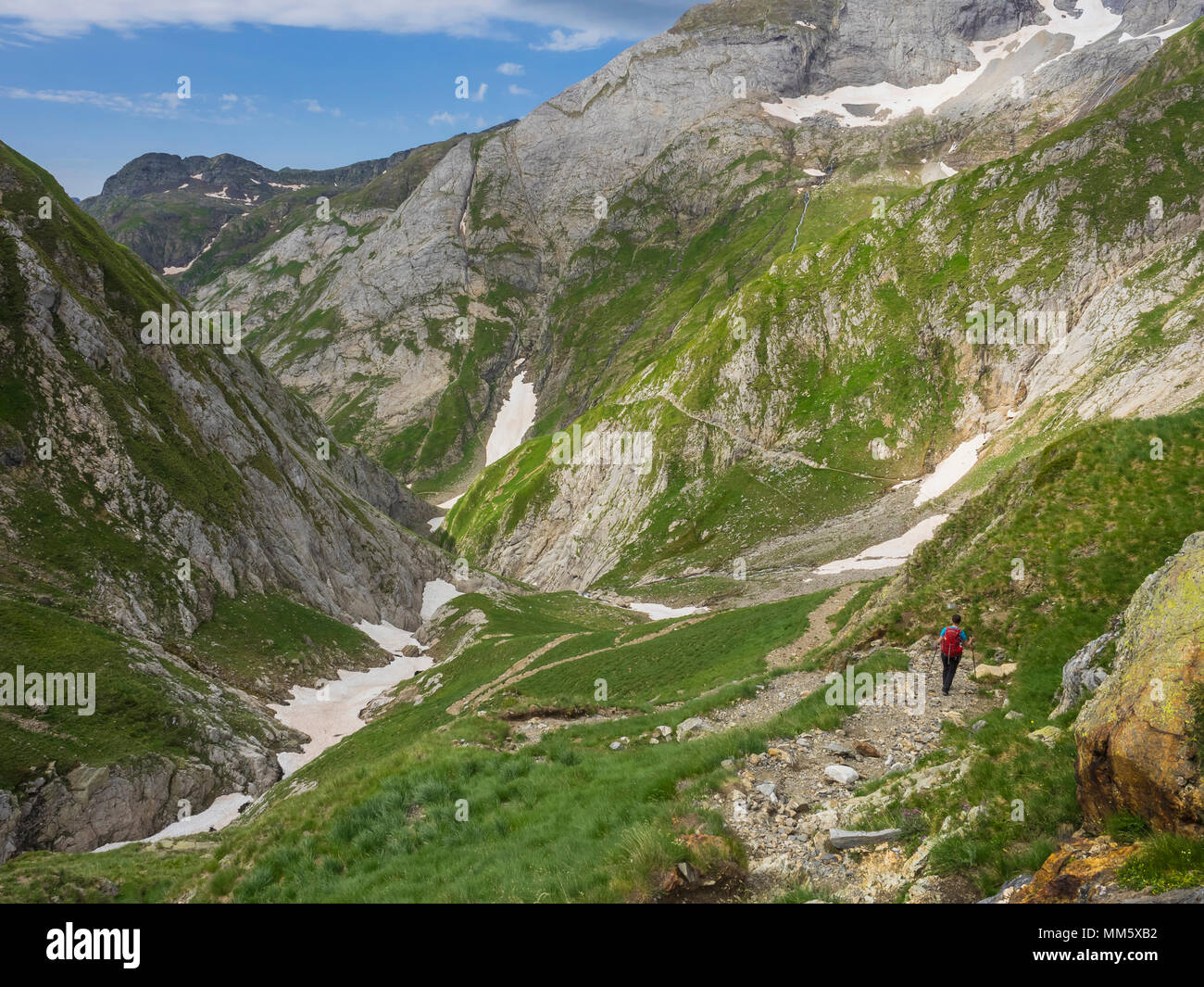Woman hiking in the High Pyrenees descending from Hourquette d'Ossoue ...