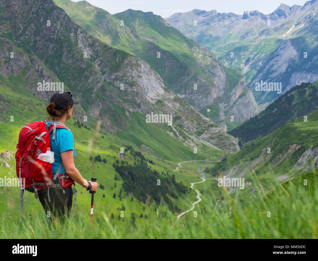 Woman hiking in the High Pyrenees descending Oulettes d'Ossoue towards ...