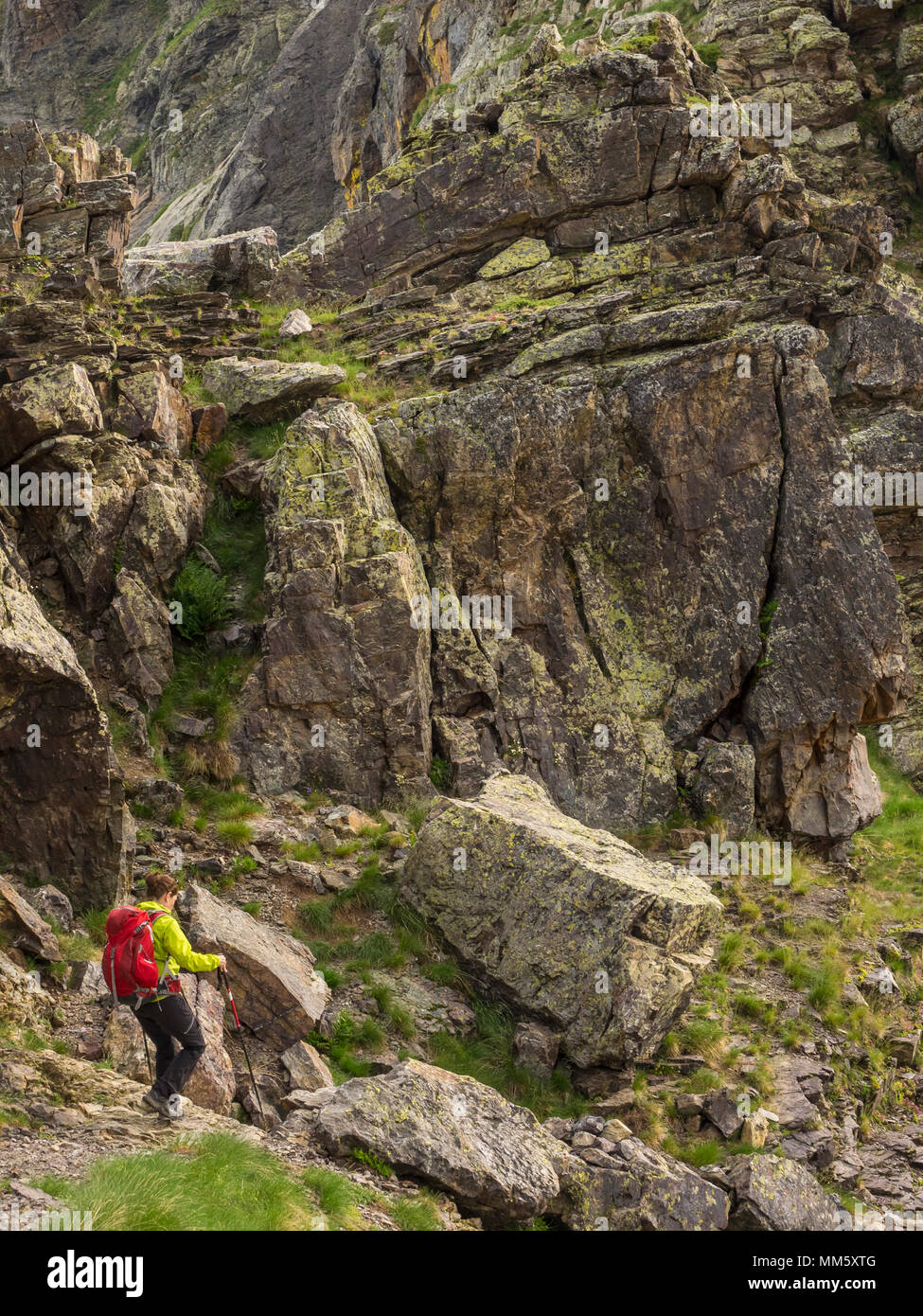 Woman hiking in the High Pyrenees descending from Hourquette d'Alans ...