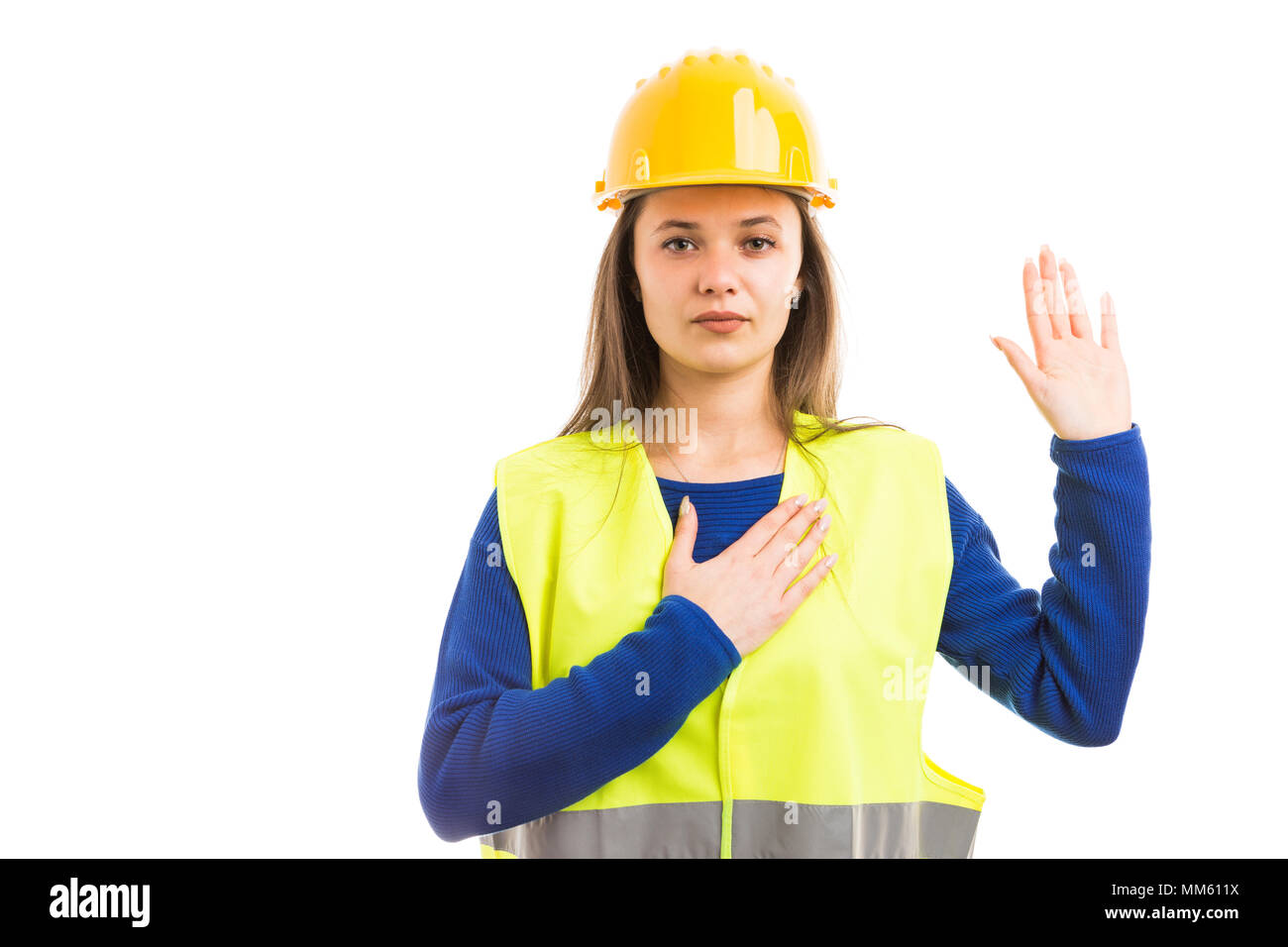 Young female architect or engineer making vow gesture with raised hand ...
