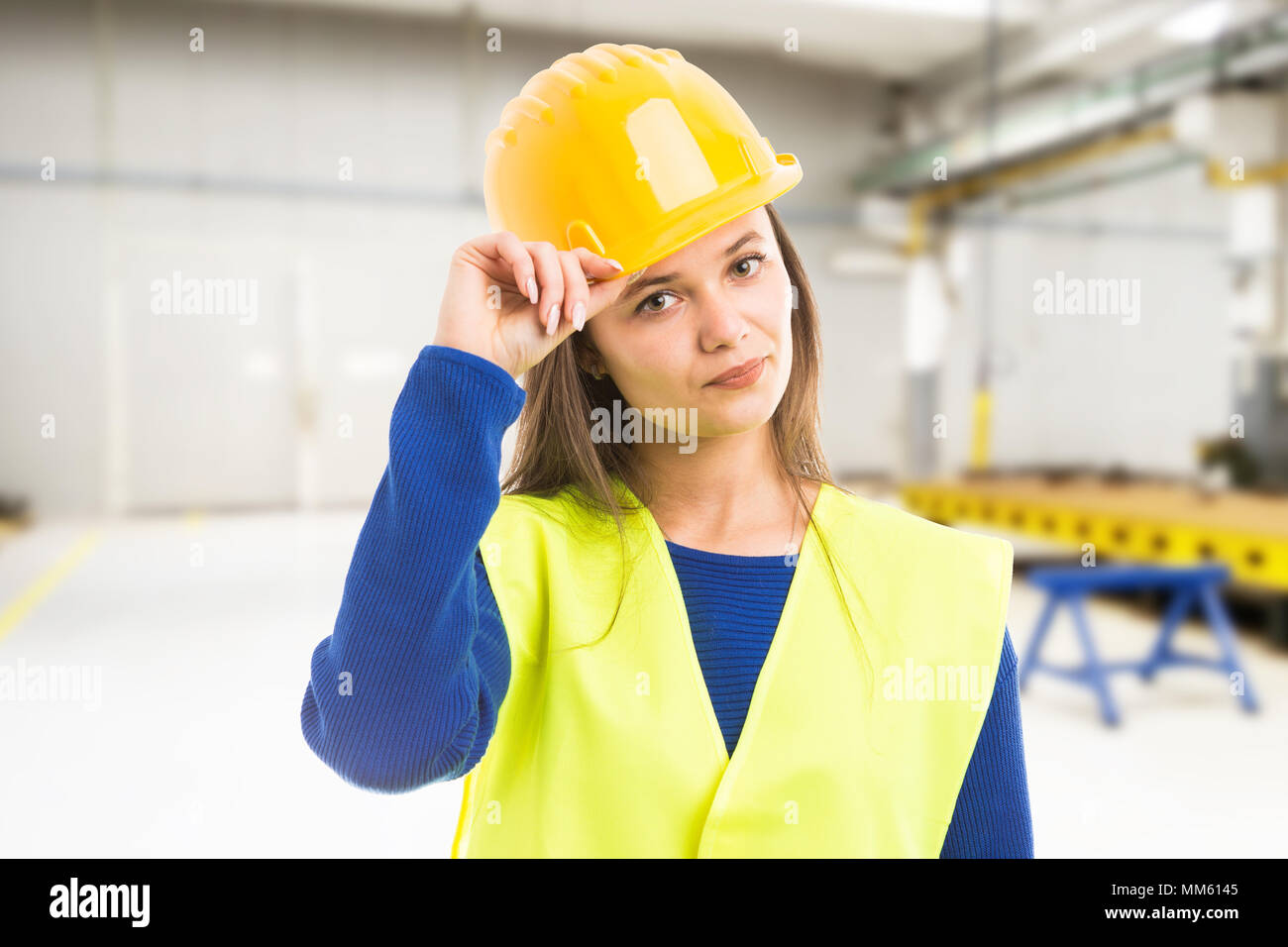 Young attractive female engineer greeting by making a polite salute ...