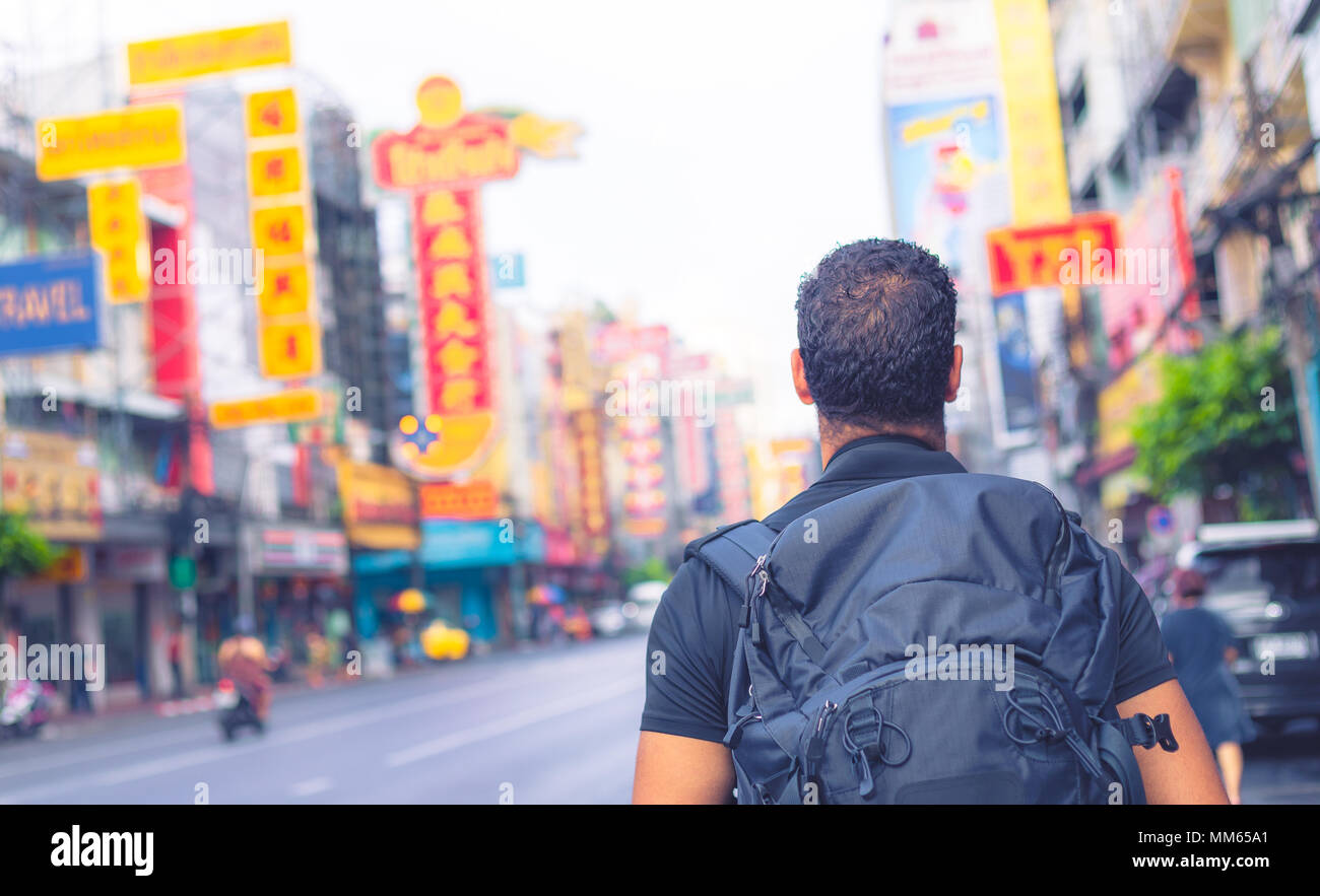 back of a backpacker exploring yaowarat road in Bangkok , Thailand ...