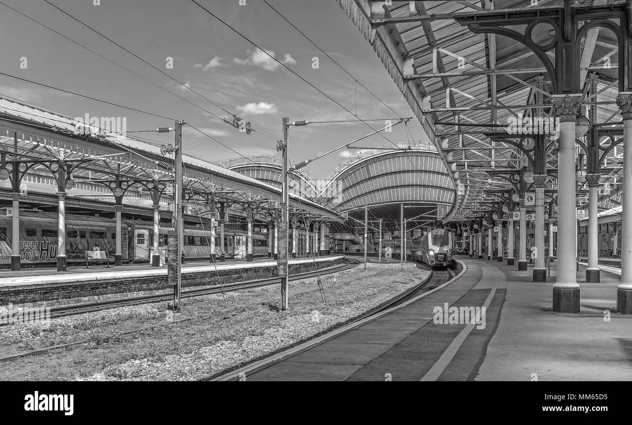 An ornate 19th Century canopy curves into the station. Two trains prepare to depart Stock Photo ...