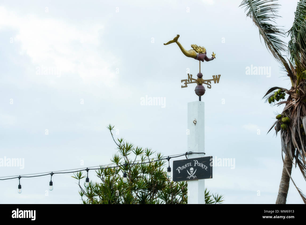 A mermaid weather vane on top of a white pole Stock Photo - Alamy