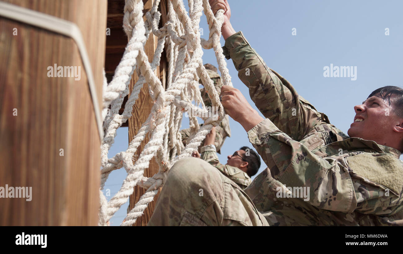 Soldiers of 1st Brigade, 1st Armored Division, climb up a net rope as ...