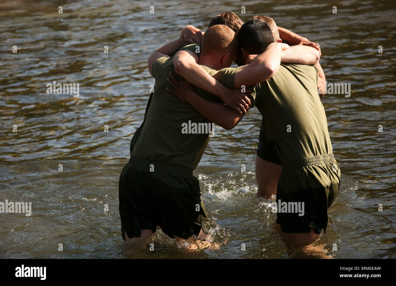 Marines work together to move through water during a stream crossing ...