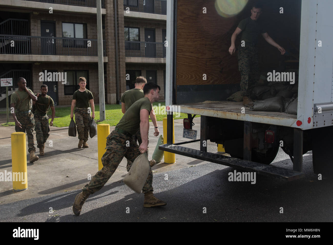U.S. Marines with Marine Corps Air Station (MCAS), remove the sandbags ...