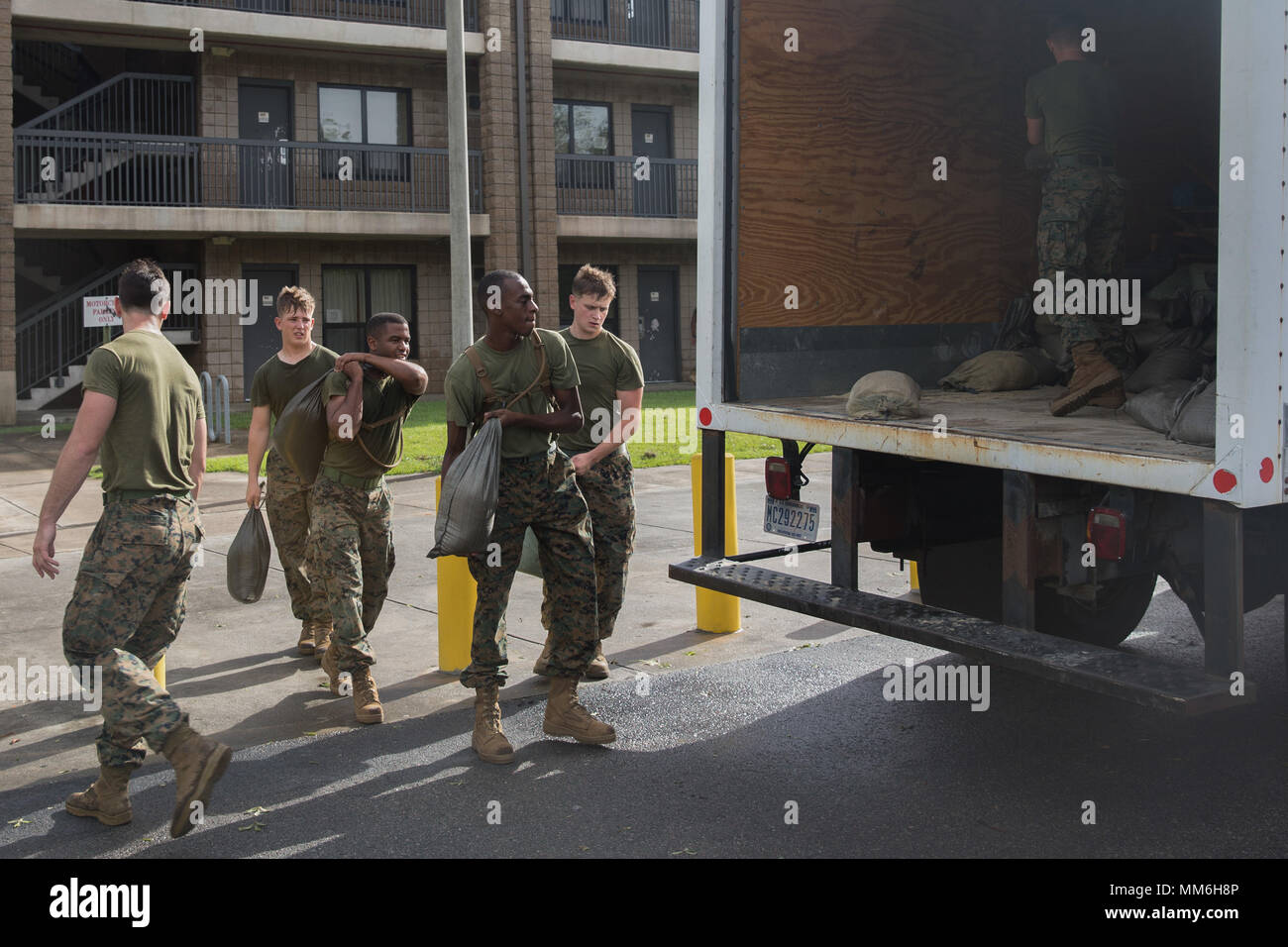 U.S. Marines with Marine Corps Air Station (MCAS), remove the sandbags ...