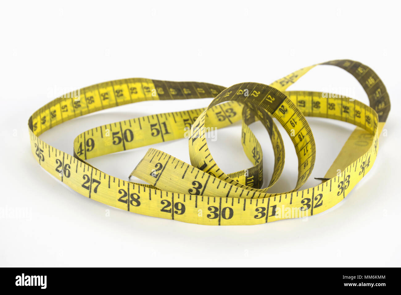 A yellow measuring tape in white background Stock Photo - Alamy