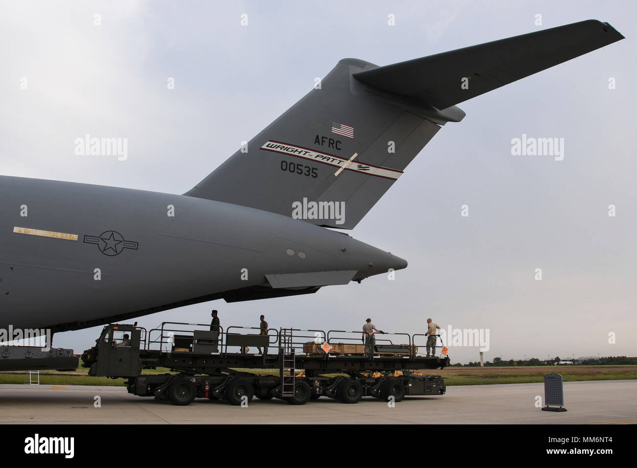A cargo transport moves in to pusition under the tail of a C-17A from ...