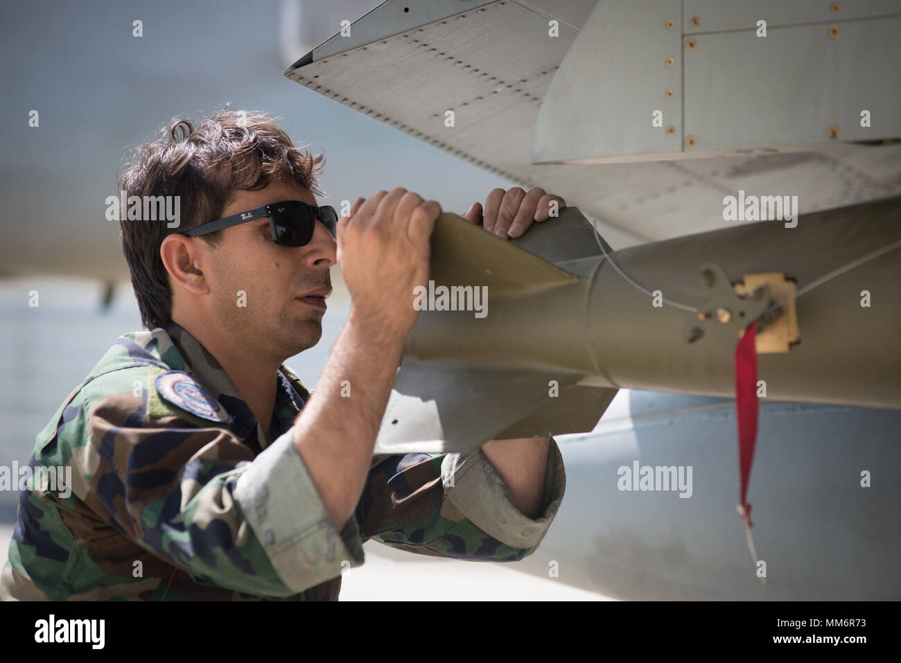 An Afghan Airman checks the alignment of an MK-81 bomb underneath the ...