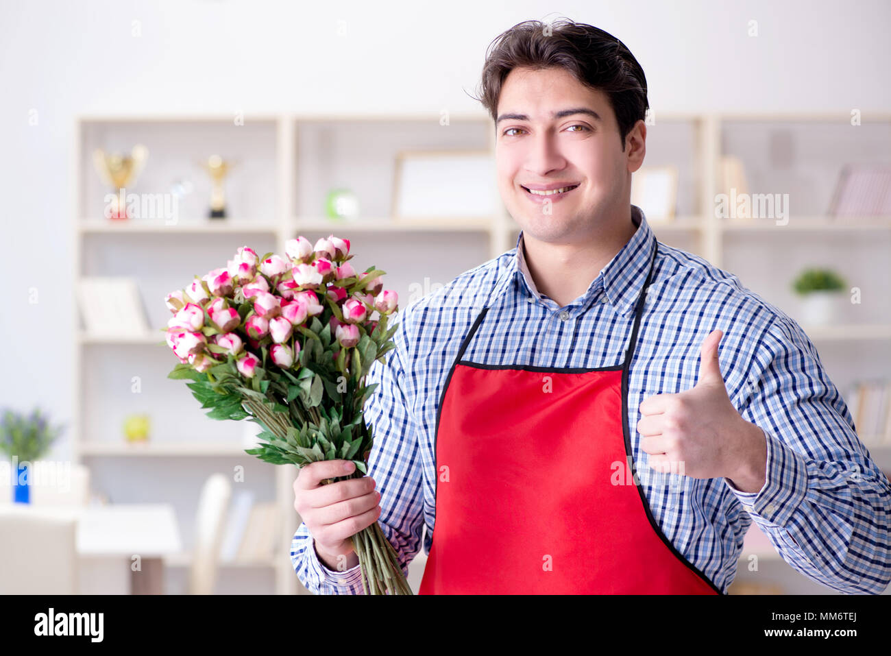 Flower shop assistant offering a bunch of flowers Stock Photo - Alamy
