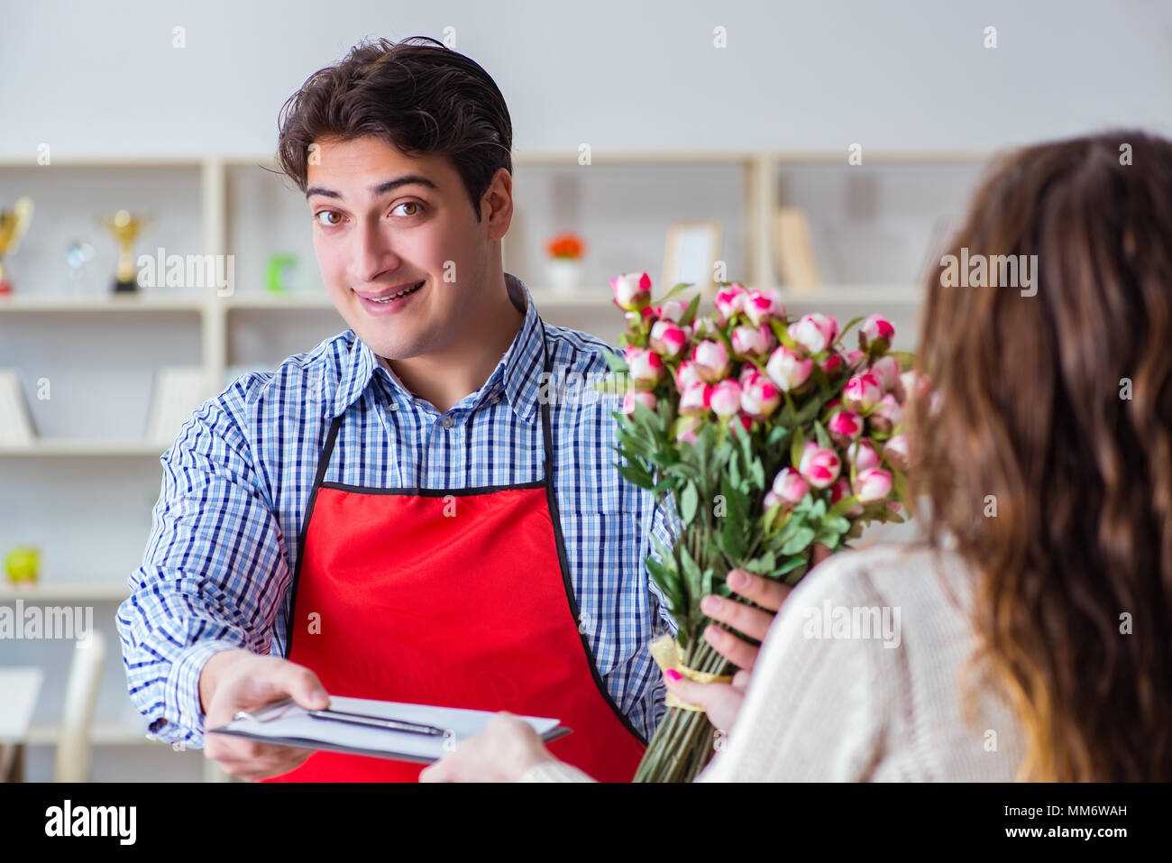 Flower shop assistant selling flowers to female customer Stock Photo ...
