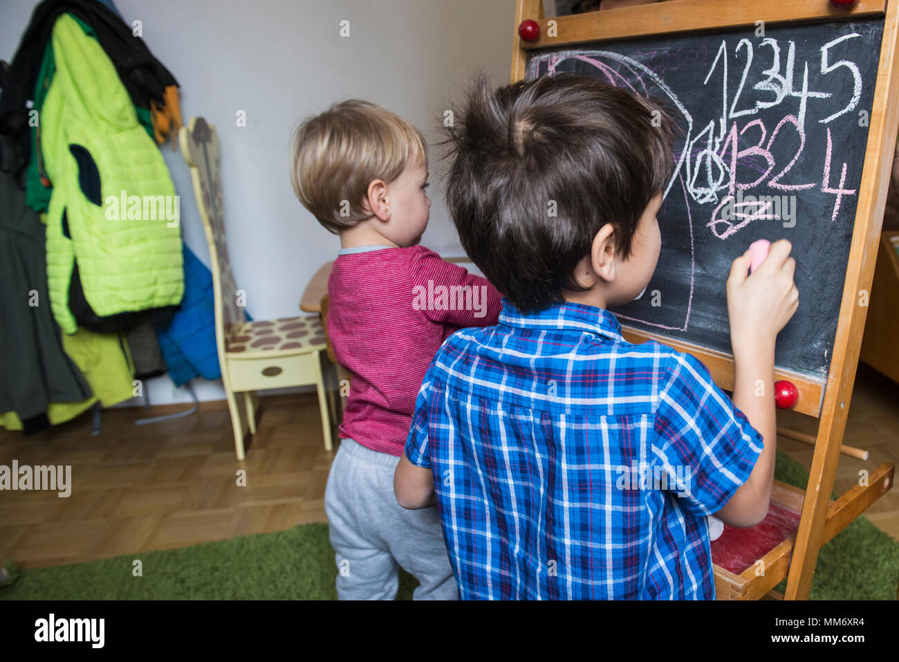 Brothers writing on a blackboard, Munich, Germany Stock Photo - Alamy