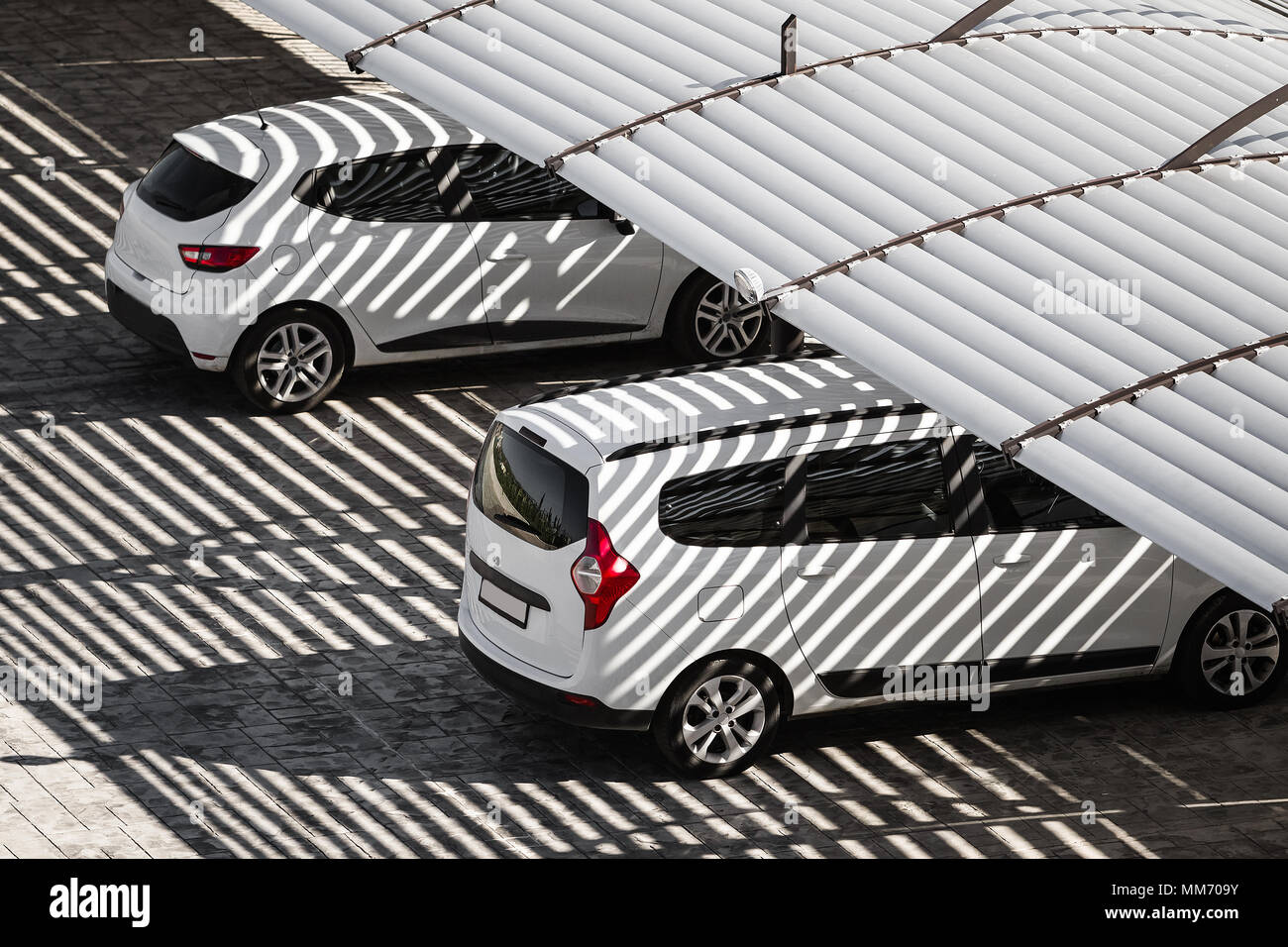 Cars on a parking lot under the shadow Stock Photo - Alamy