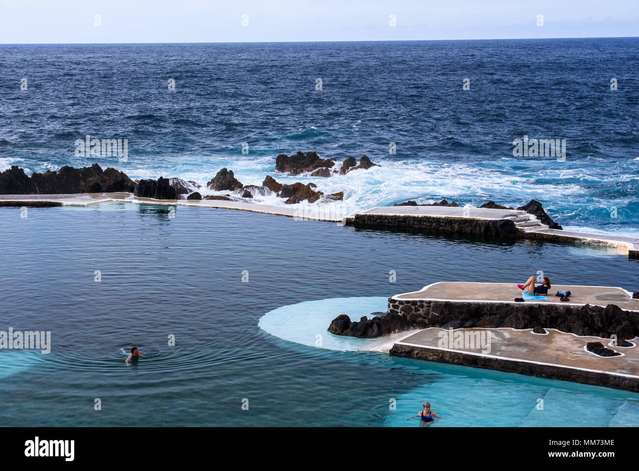 Few people at natural lava swimming pool in Porto Moniz. Madeira island, Portugal Stock Photo ...