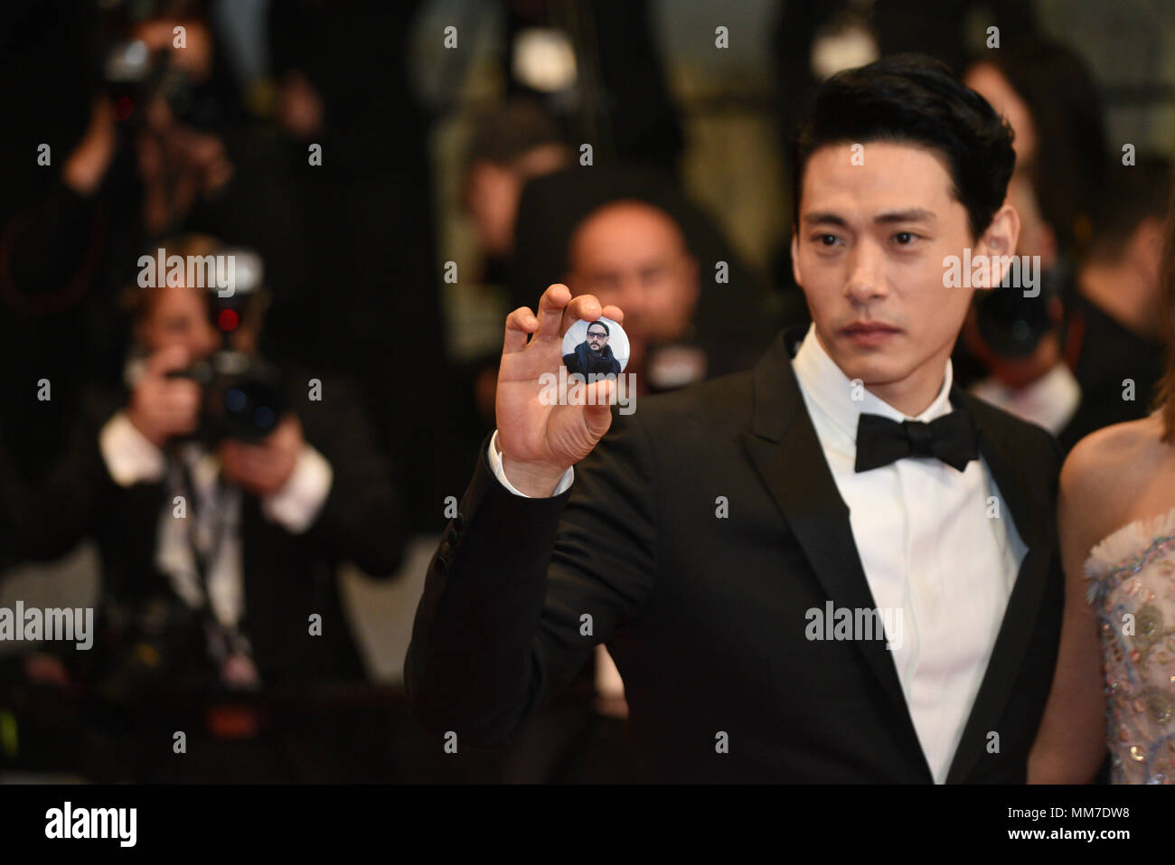 Cannes, France. 9th May, 2018. Actor Teo Yoo holds a badge with the ...