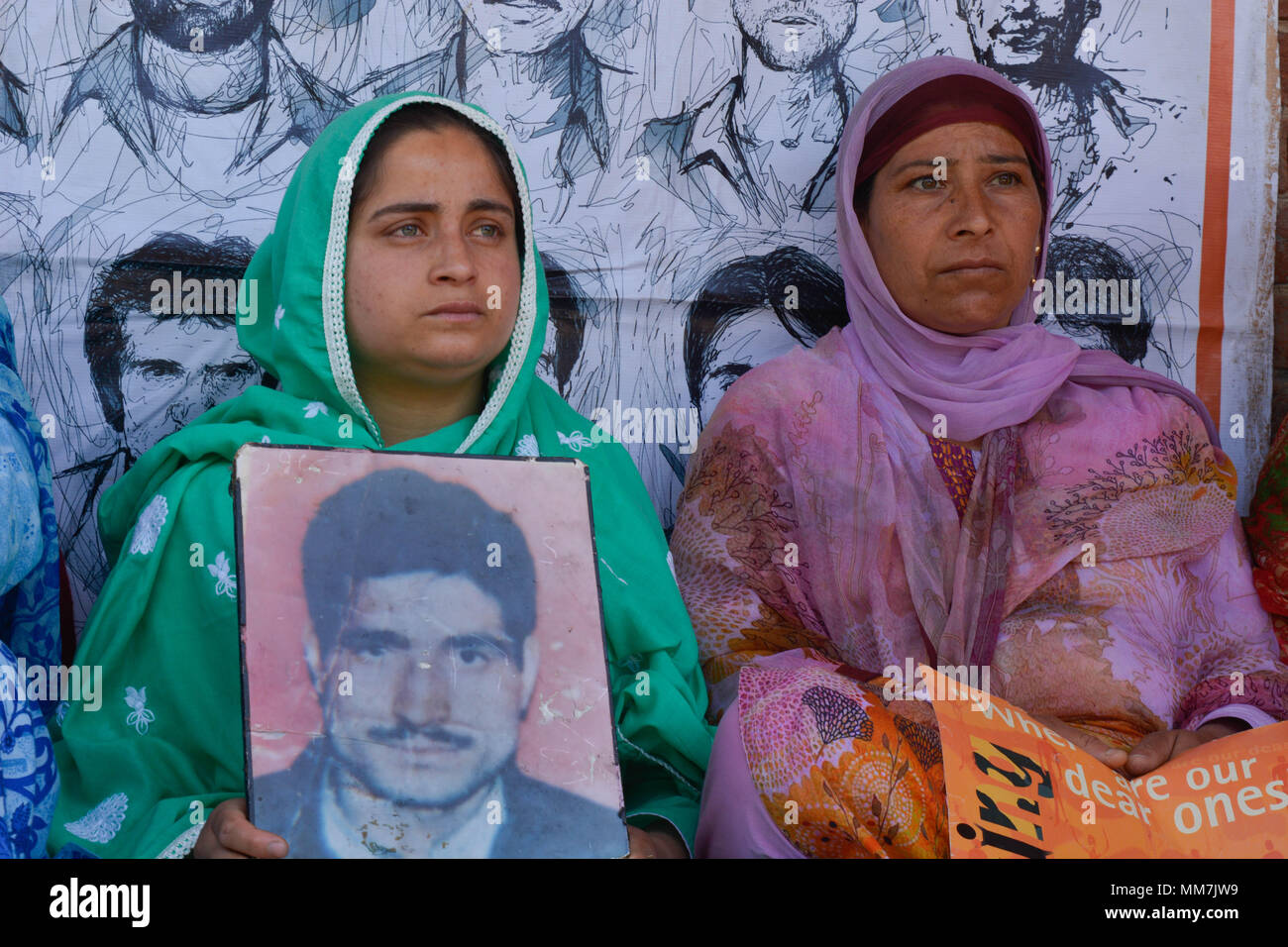Sister of Mohammad Ramzan Sheikh holds the picture of her brother at ...