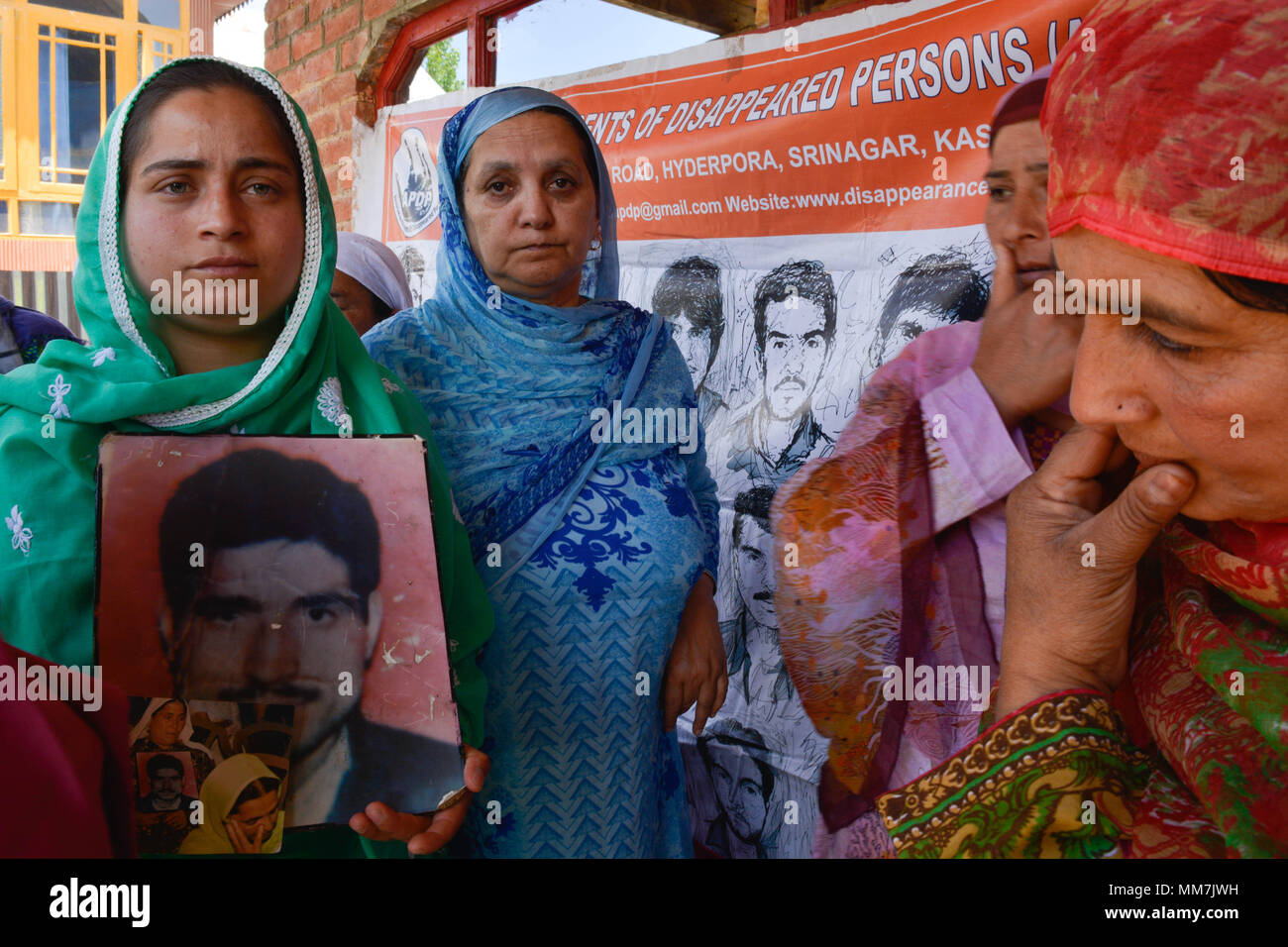 Sister of Mohammad Ramzan Sheikh holds the picture of her brother at ...