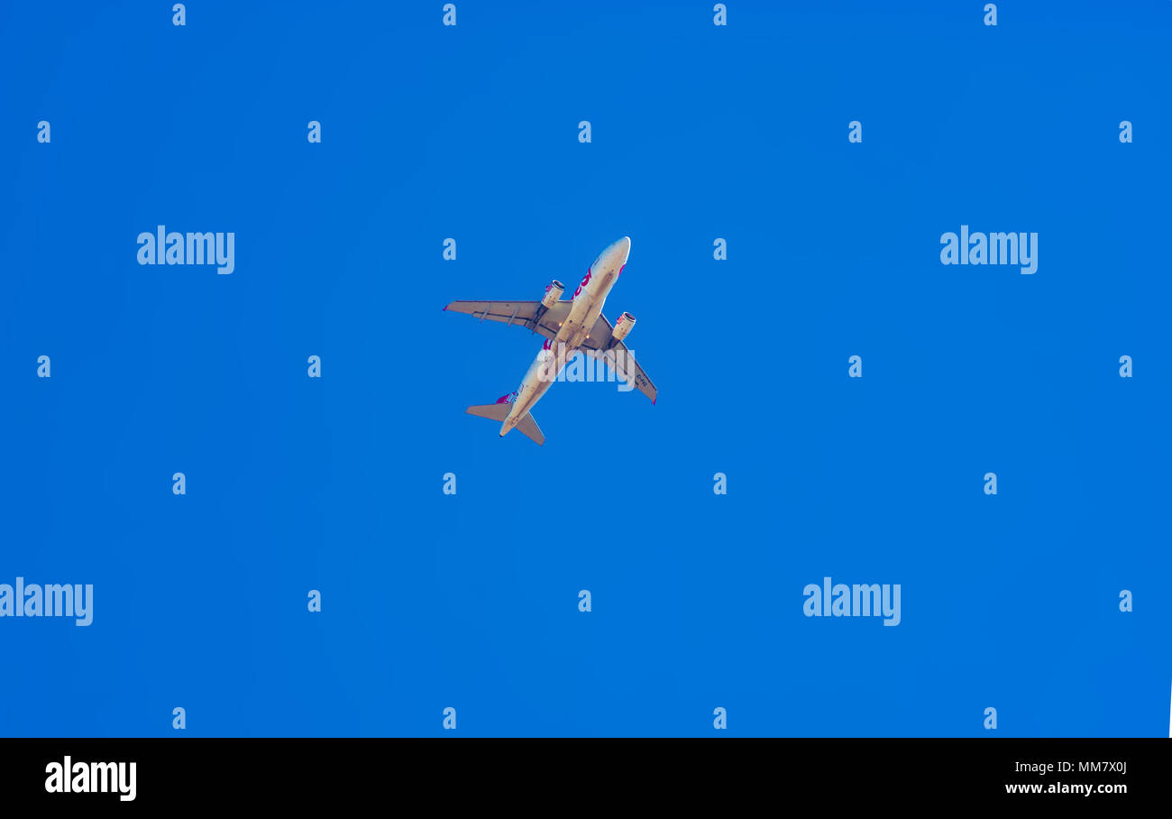 Airplane flying across blue sky hi-res stock photography and images - Alamy