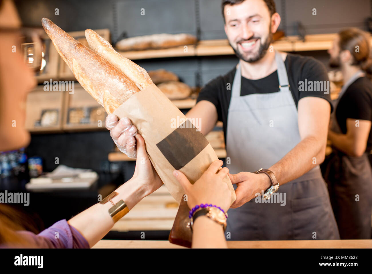 Woman buying bread in the bakery shop with man sellers Stock Photo - Alamy