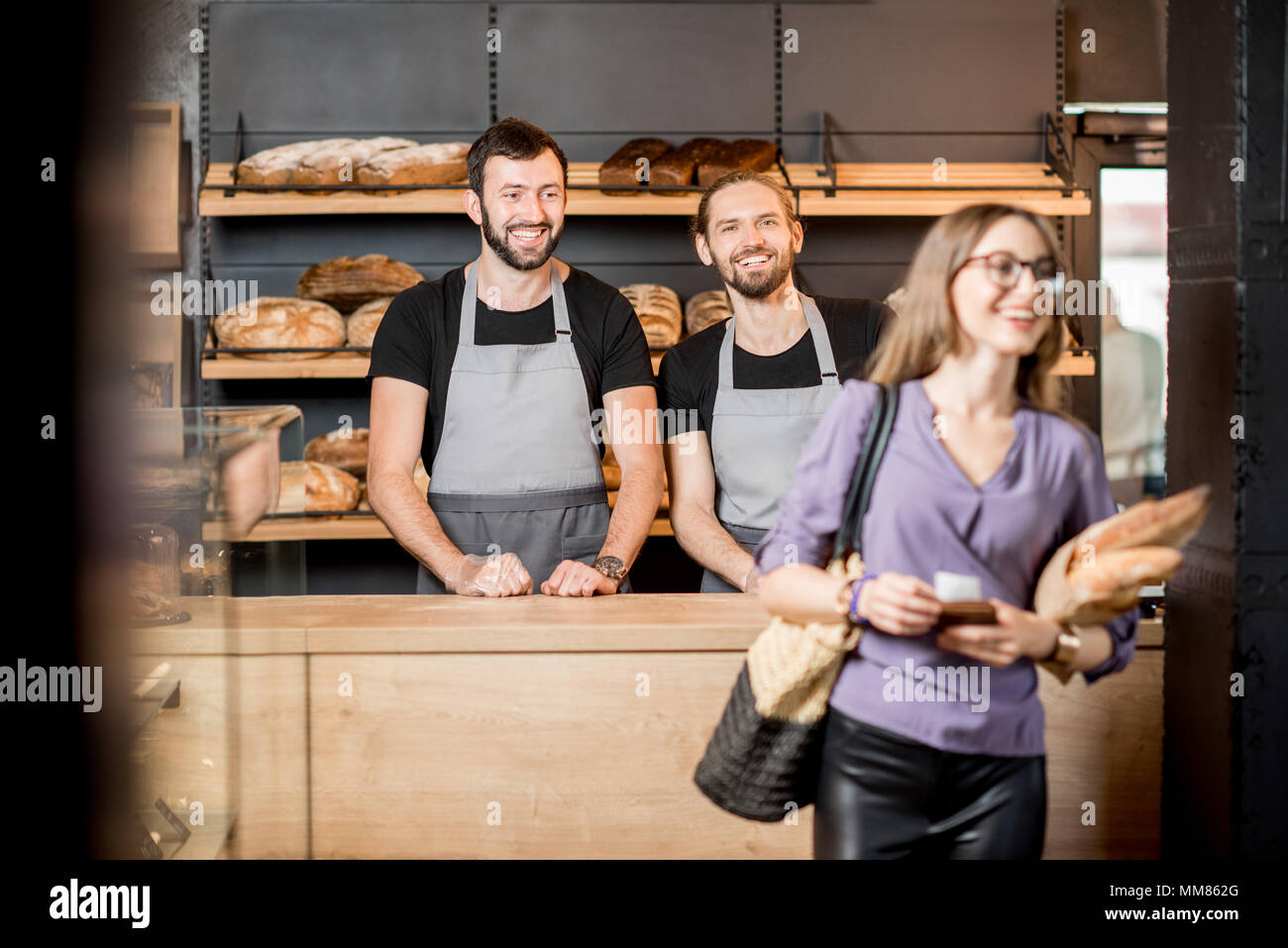Woman buying bread in the bakery shop with man sellers Stock Photo - Alamy