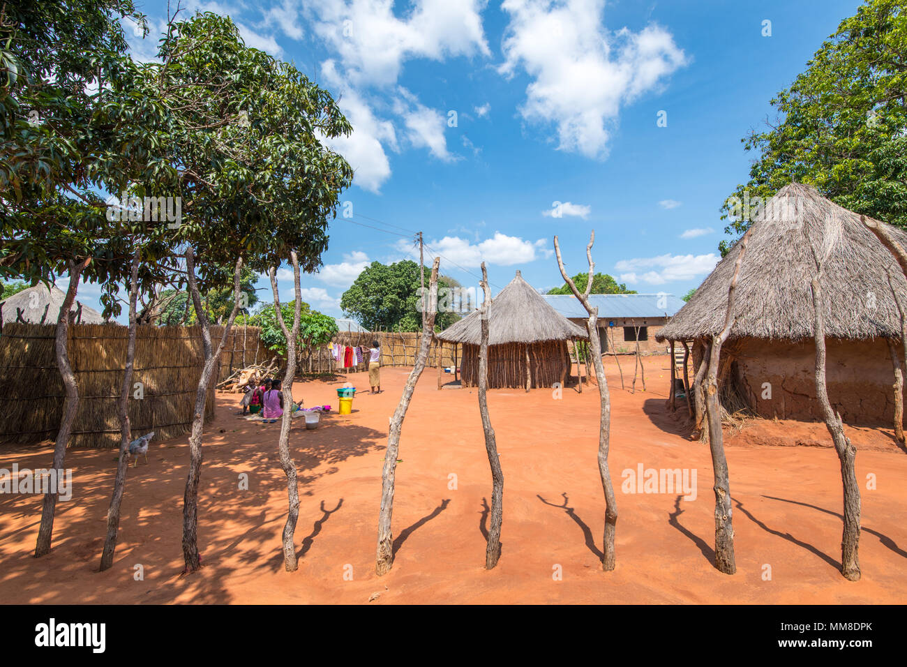 Tall wooden sticks mark the border's edge of village with blue skies ...