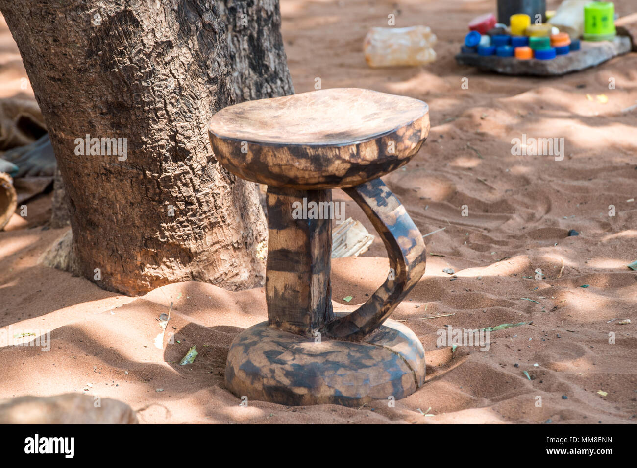 Hand craved stool sits on top of sandy ground, Mukuni Village, Zambia ...