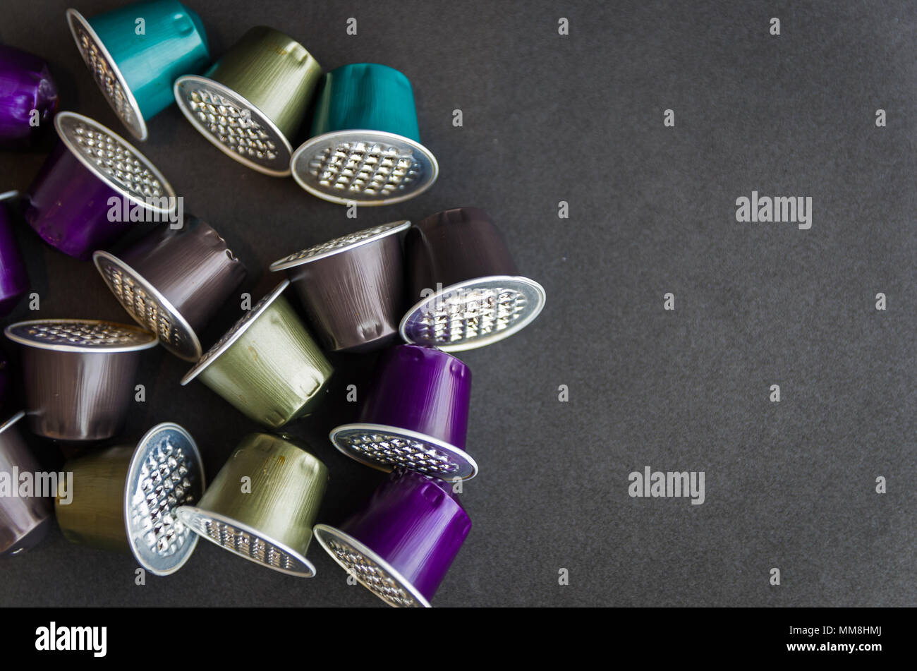 Colorful espresso coffee capsules used on black background, recycling ...