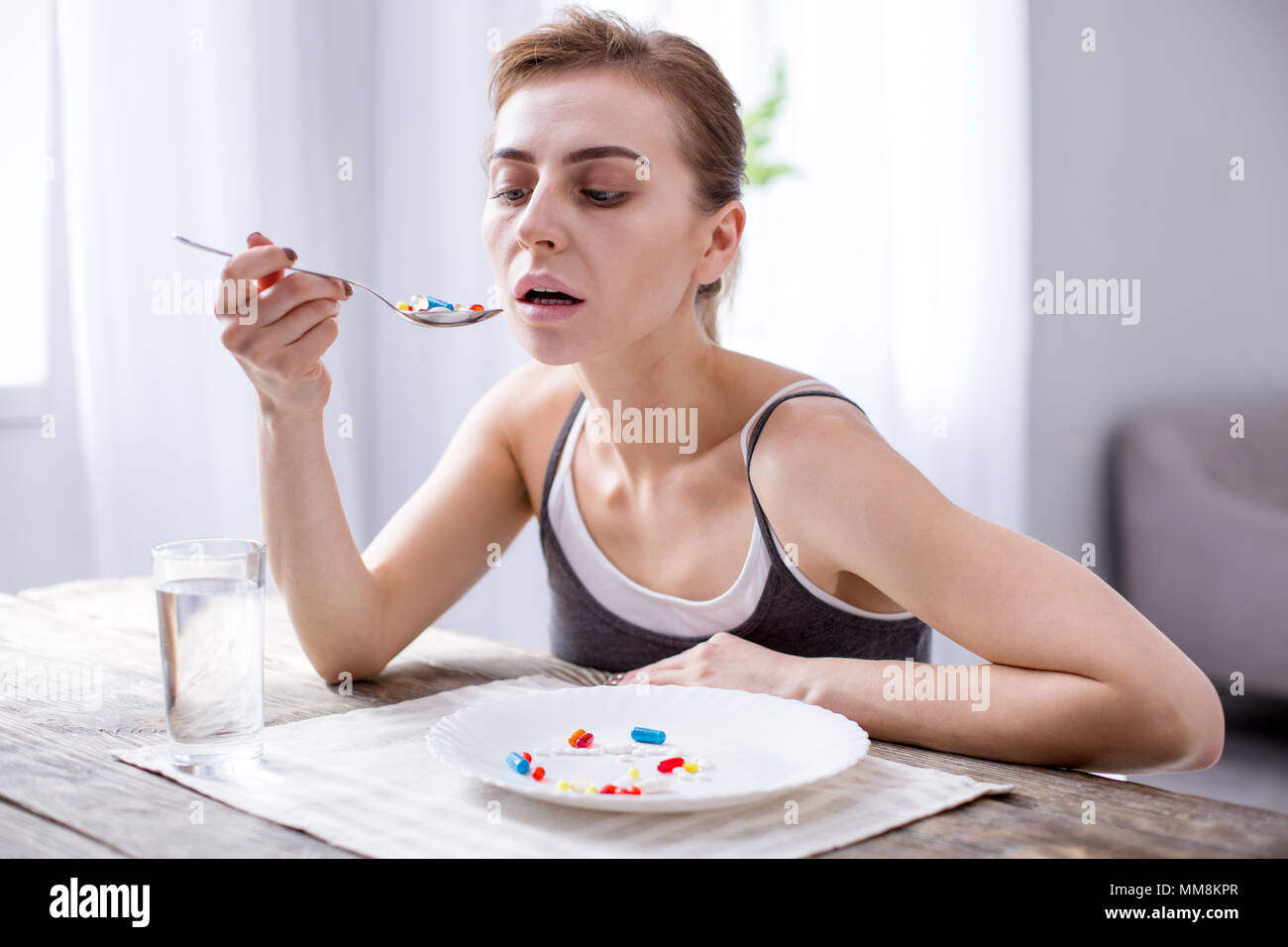 Nice sad woman sitting at the table Stock Photo - Alamy