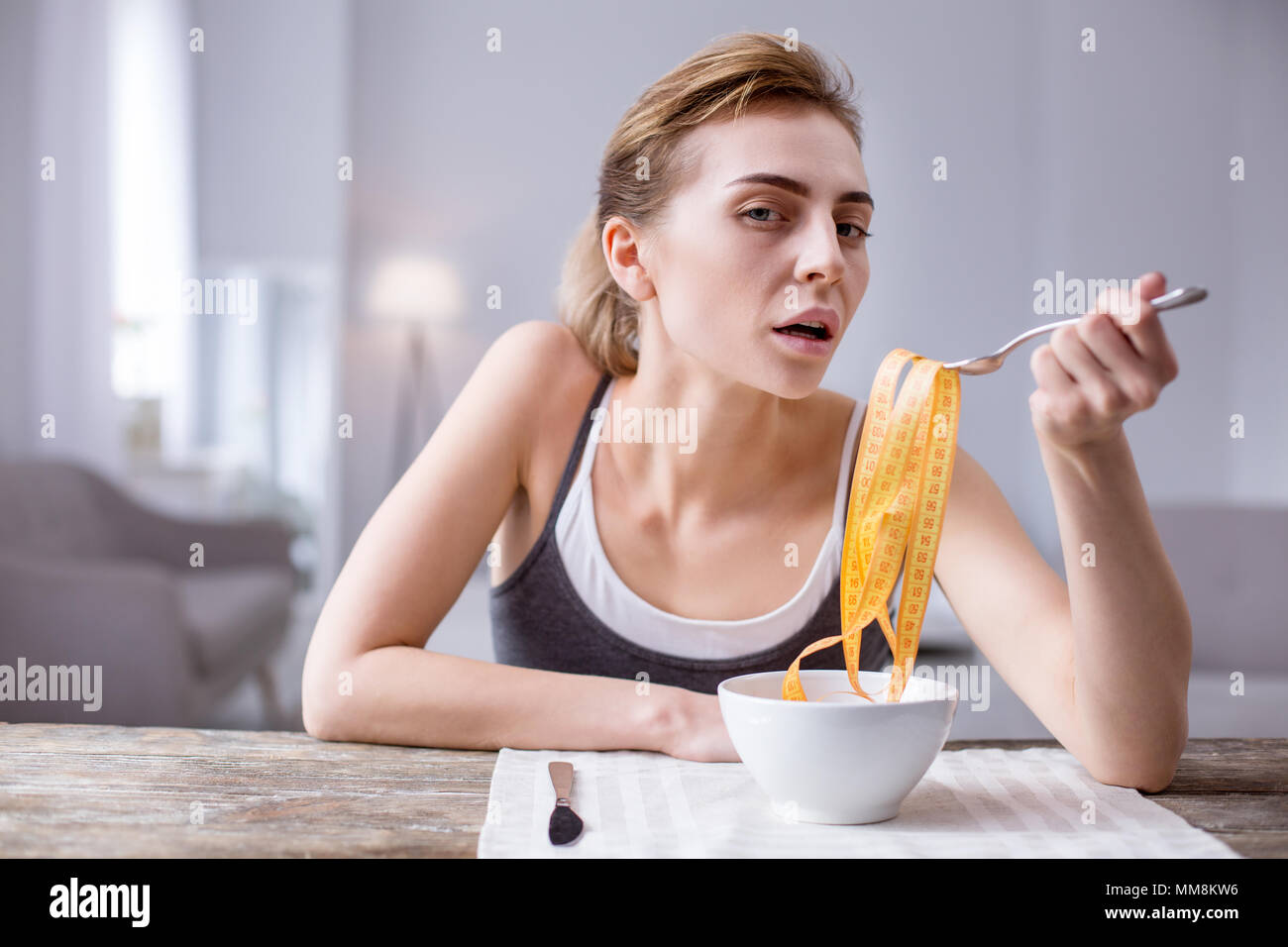 Cheerless young woman looking at you Stock Photo - Alamy