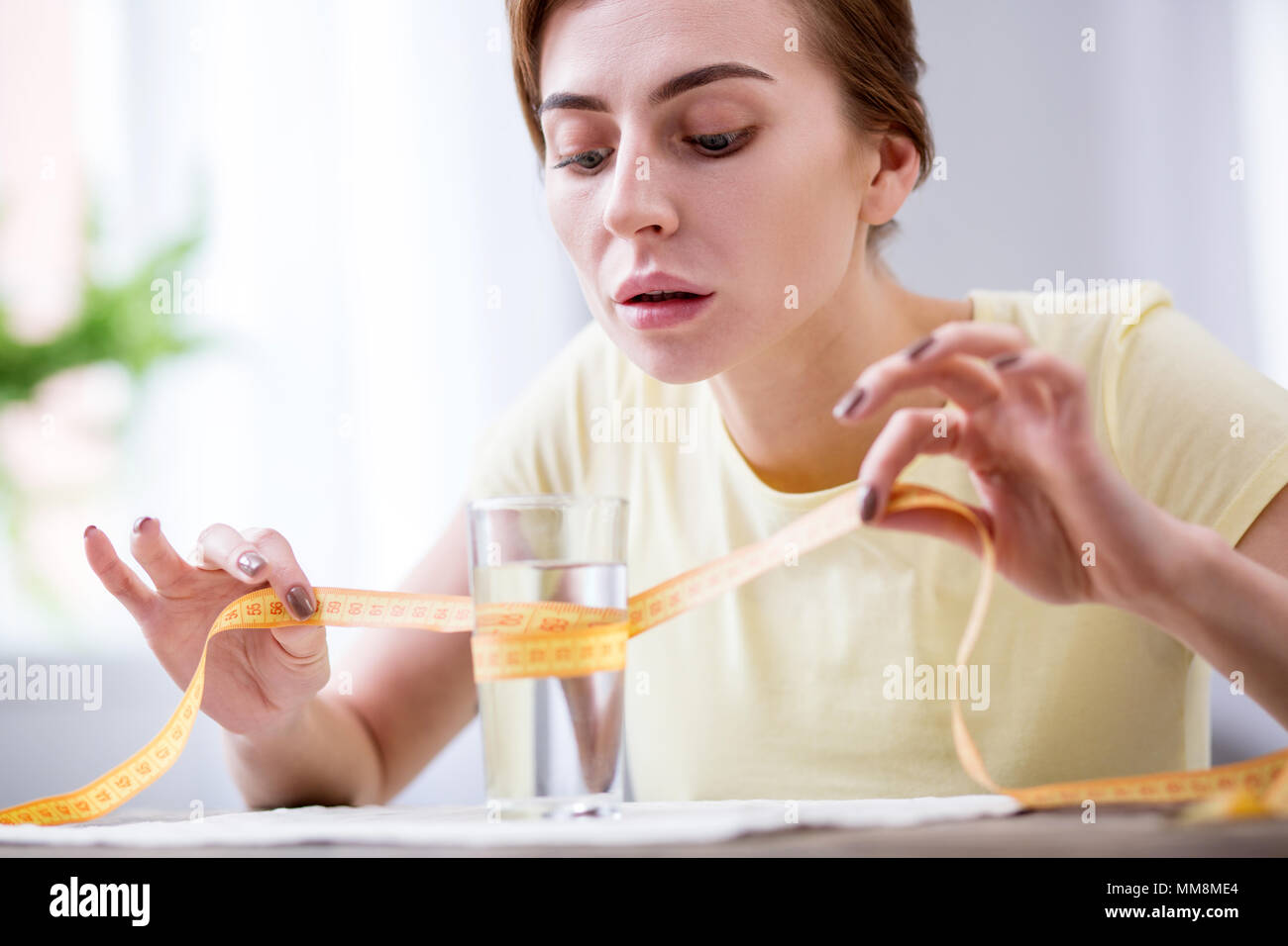 Nice young woman measuring the glass Stock Photo - Alamy