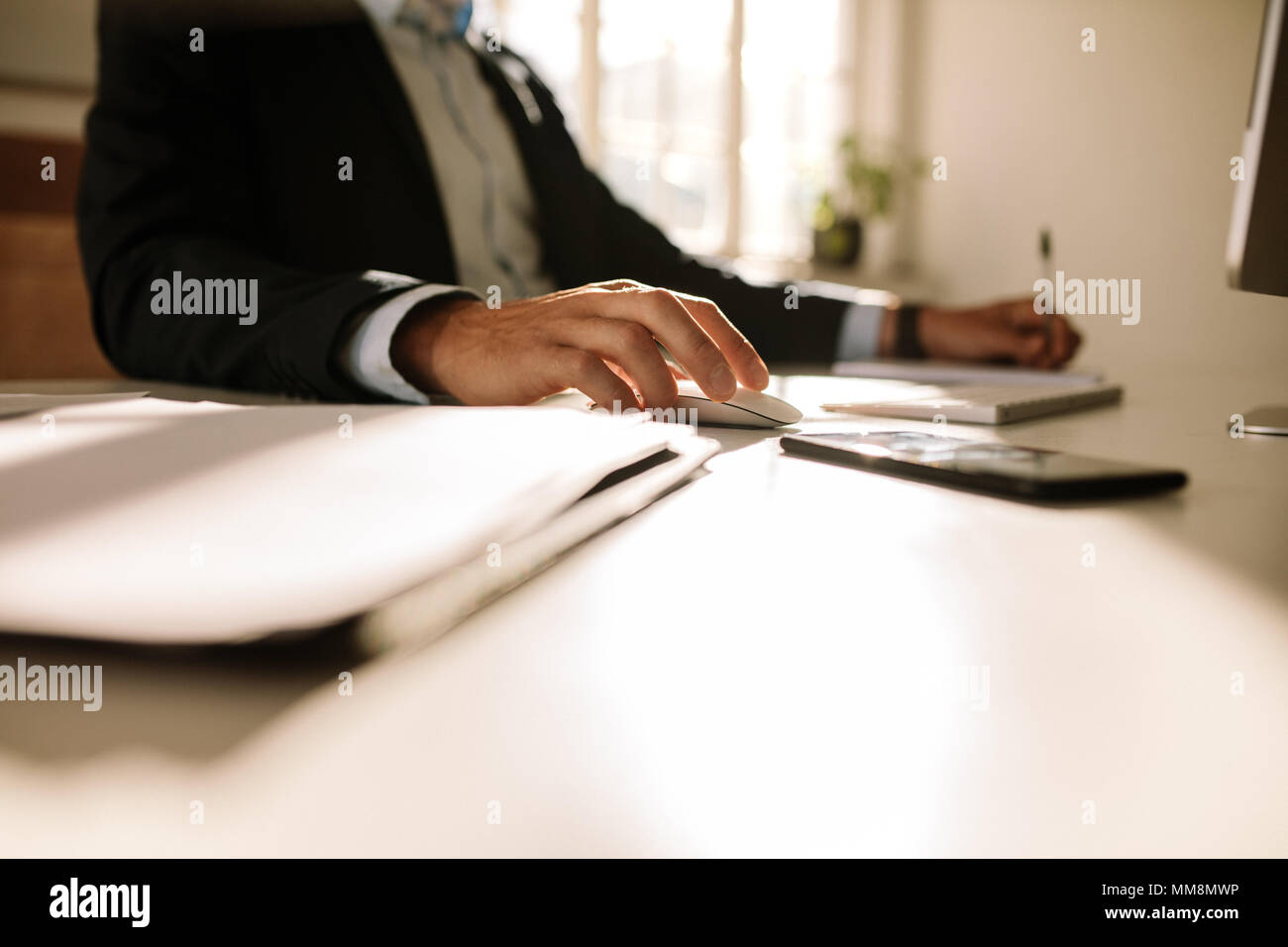Side view of businessman operating computer sitting at his table ...